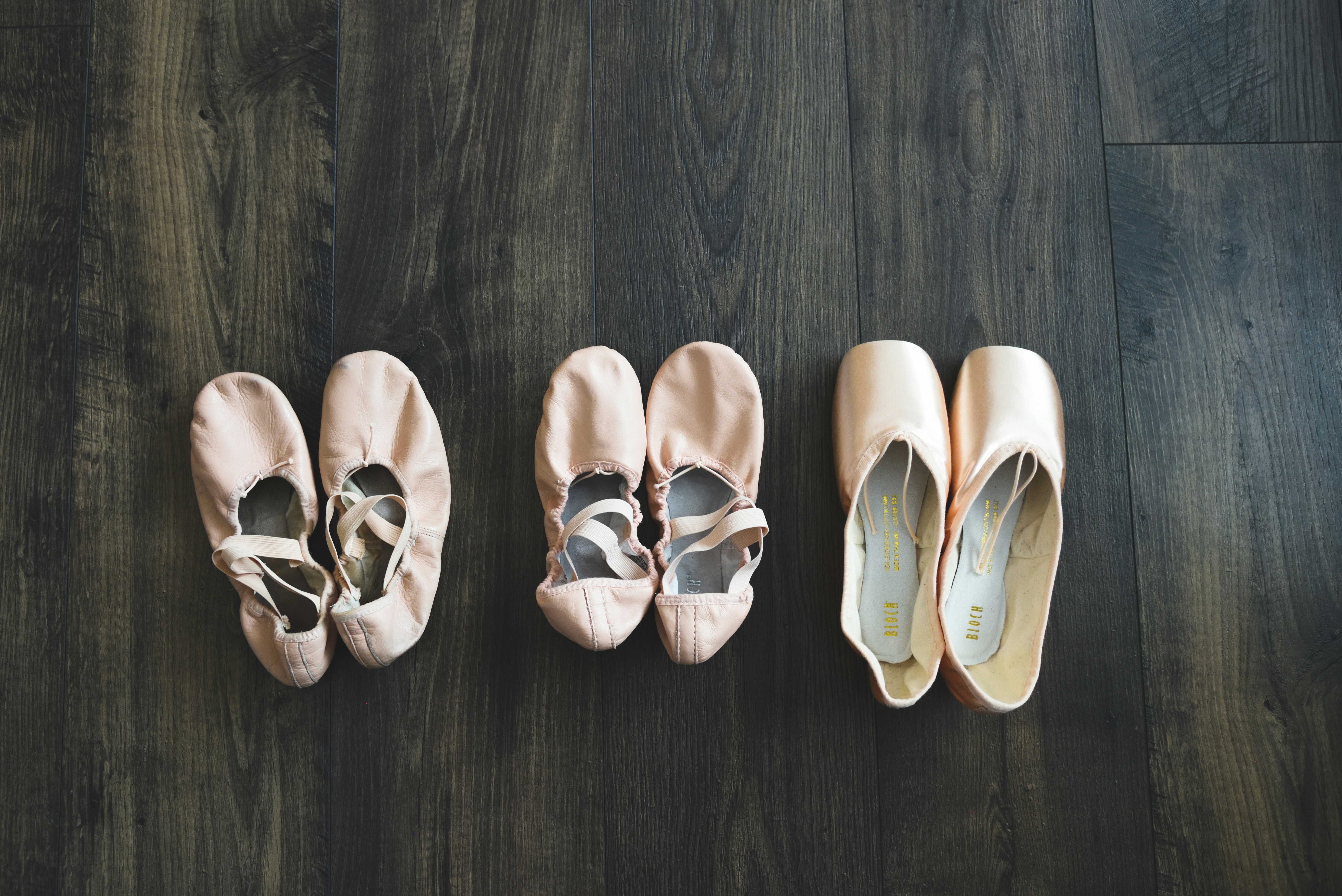 Three pairs of ballet shoes lined up on a wooden floor photo – Free ...