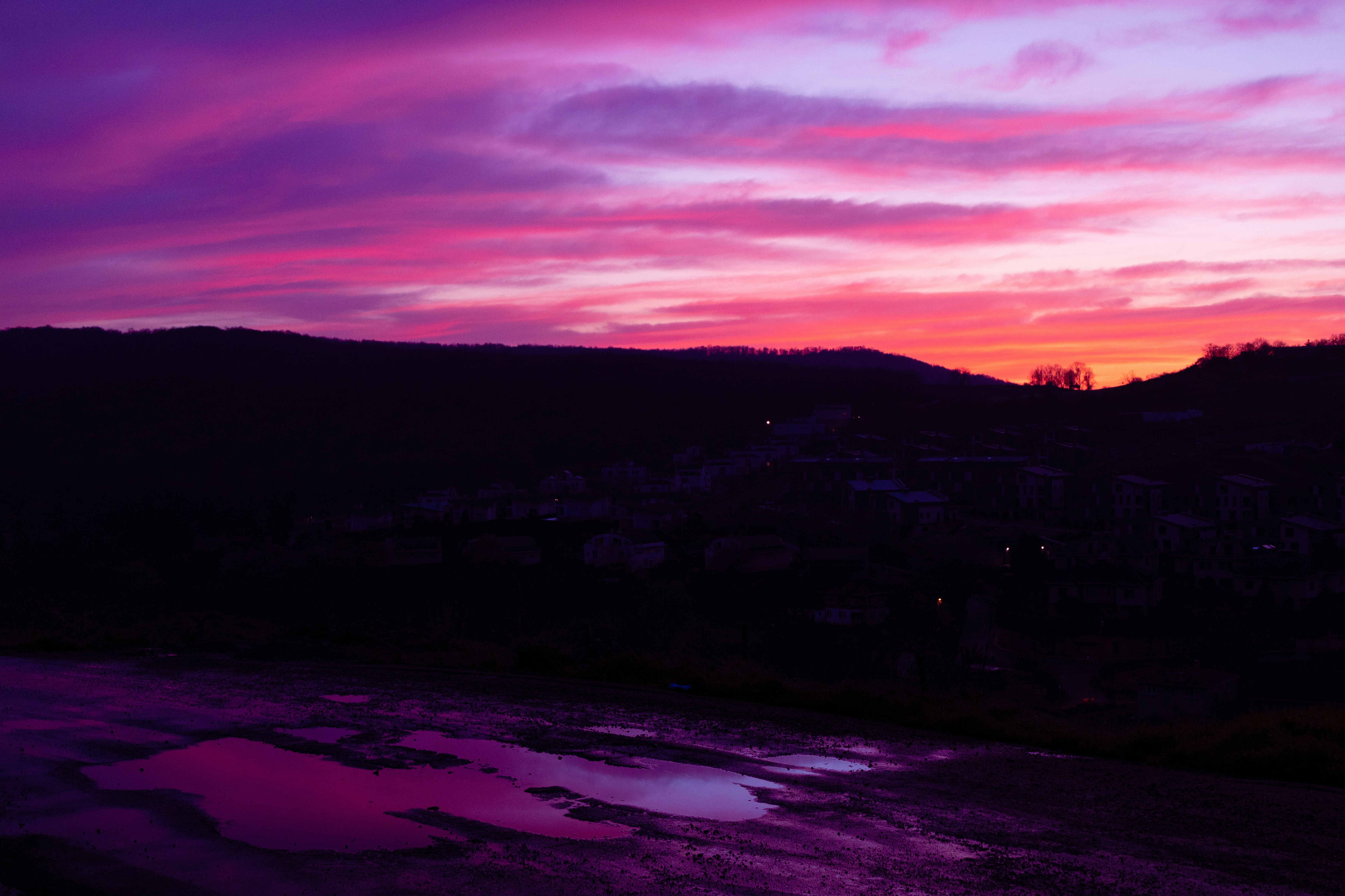 a purple and pink sunset over a small town
