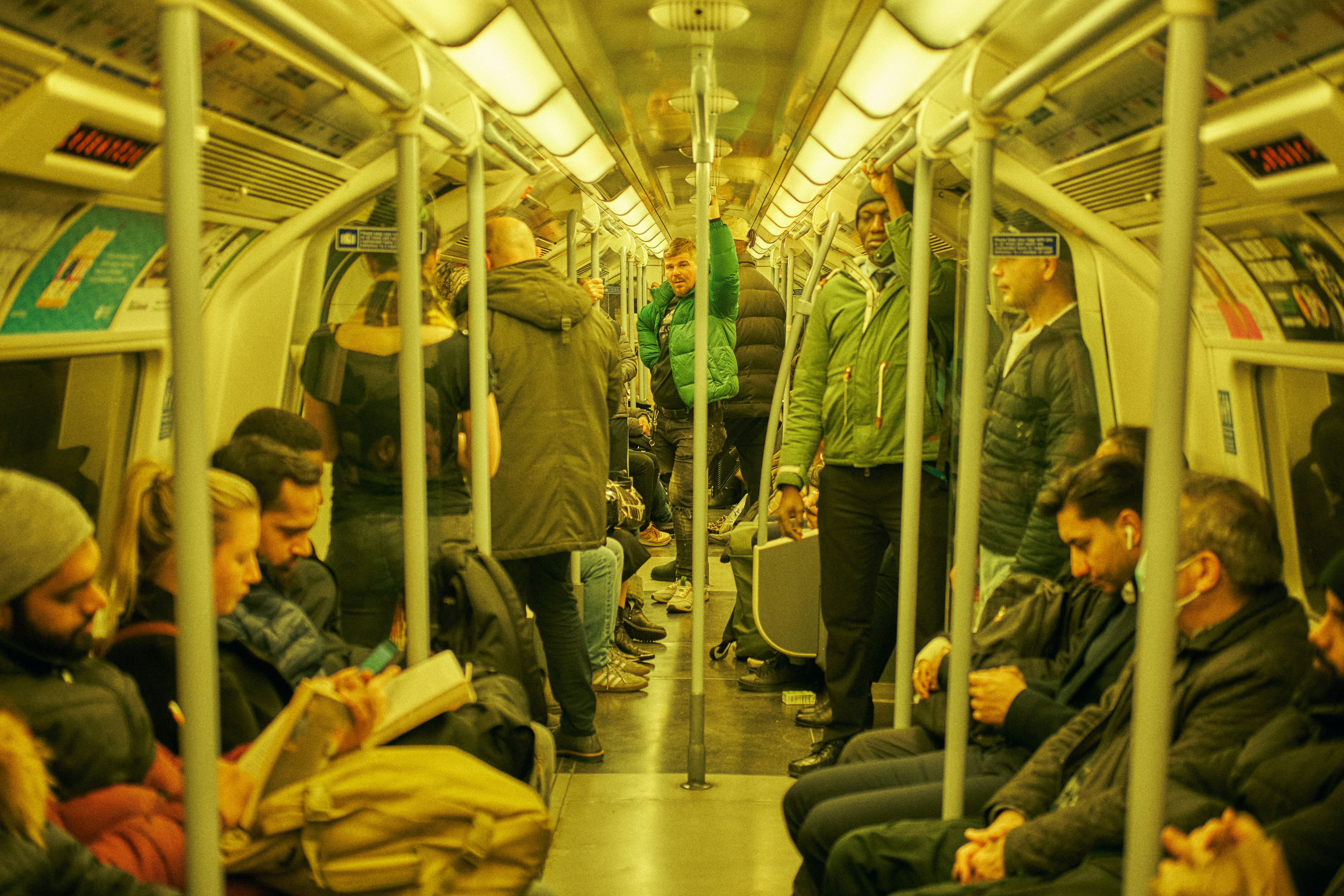 A group of people riding on a subway train photo – Free Train Image on ...