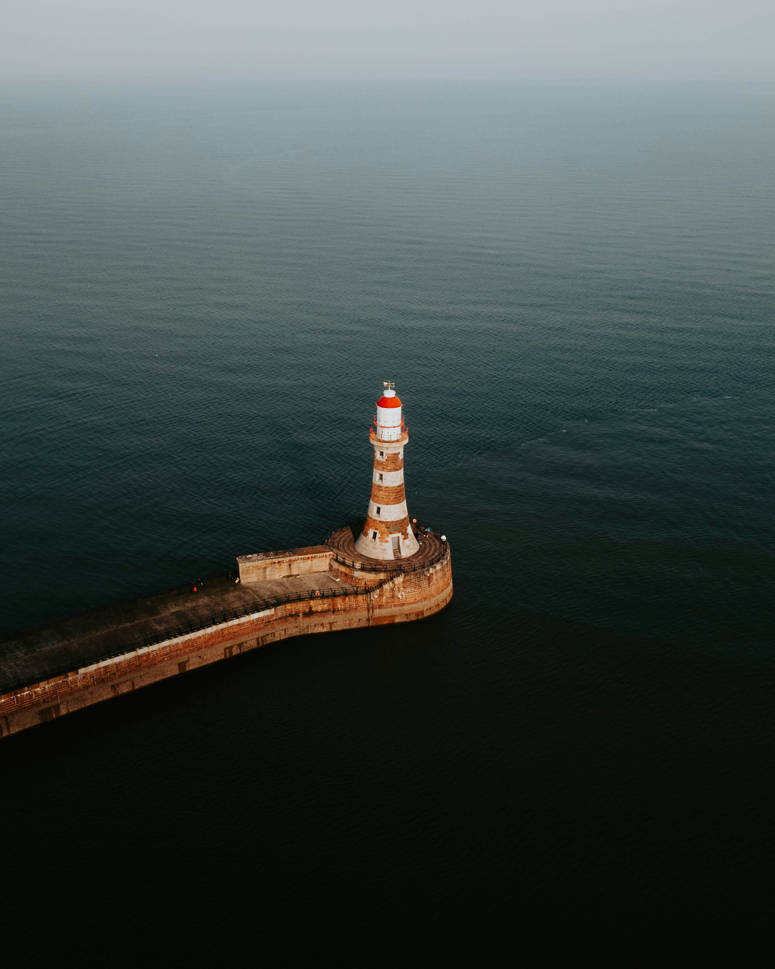 An aerial view of a light house in the middle of the ocean photo – Free ...