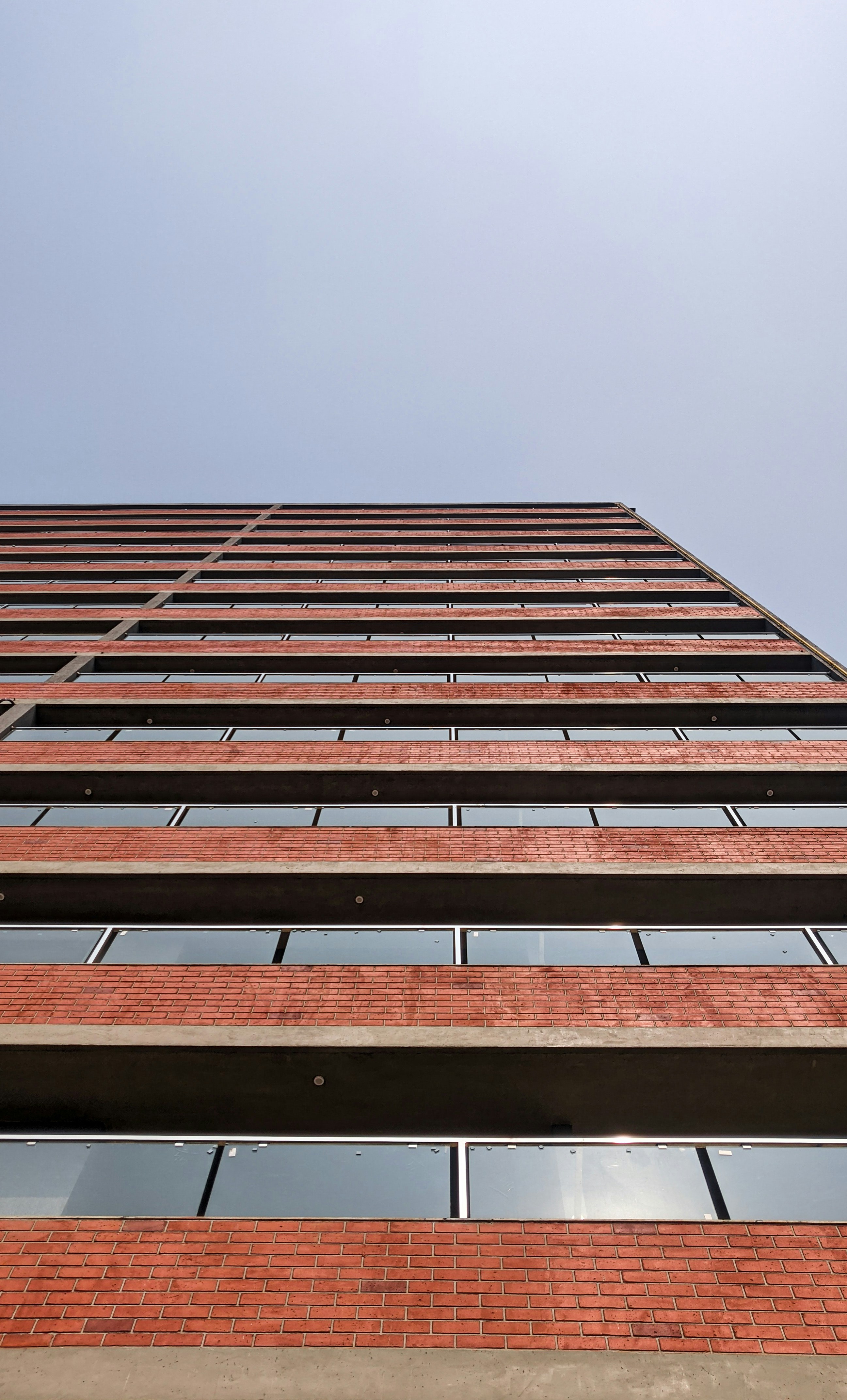 A tall red brick building with lots of windows photo – Free Building ...