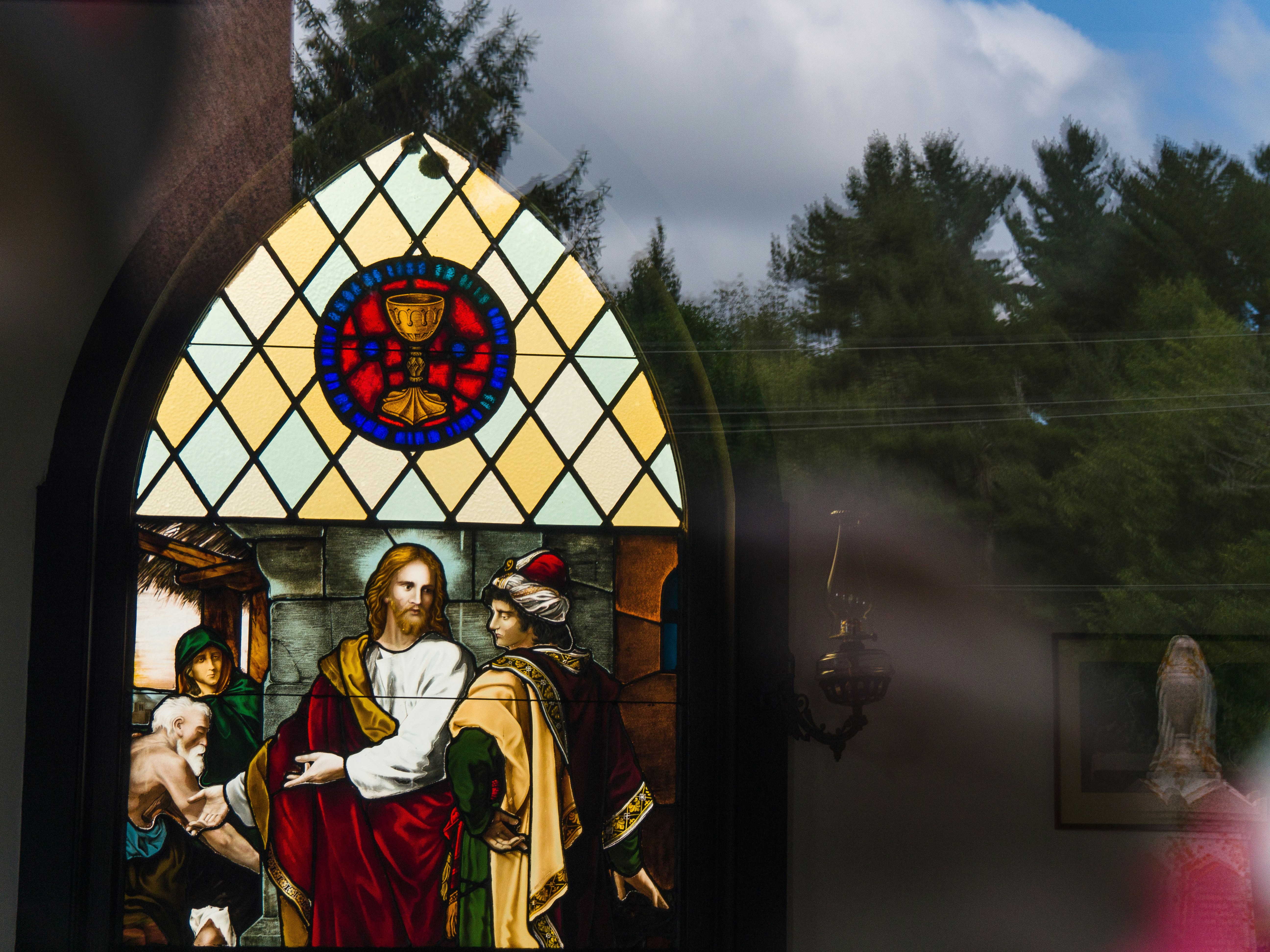 Crimson Christ Amid Stained Glass: A Quiet Church Tableau