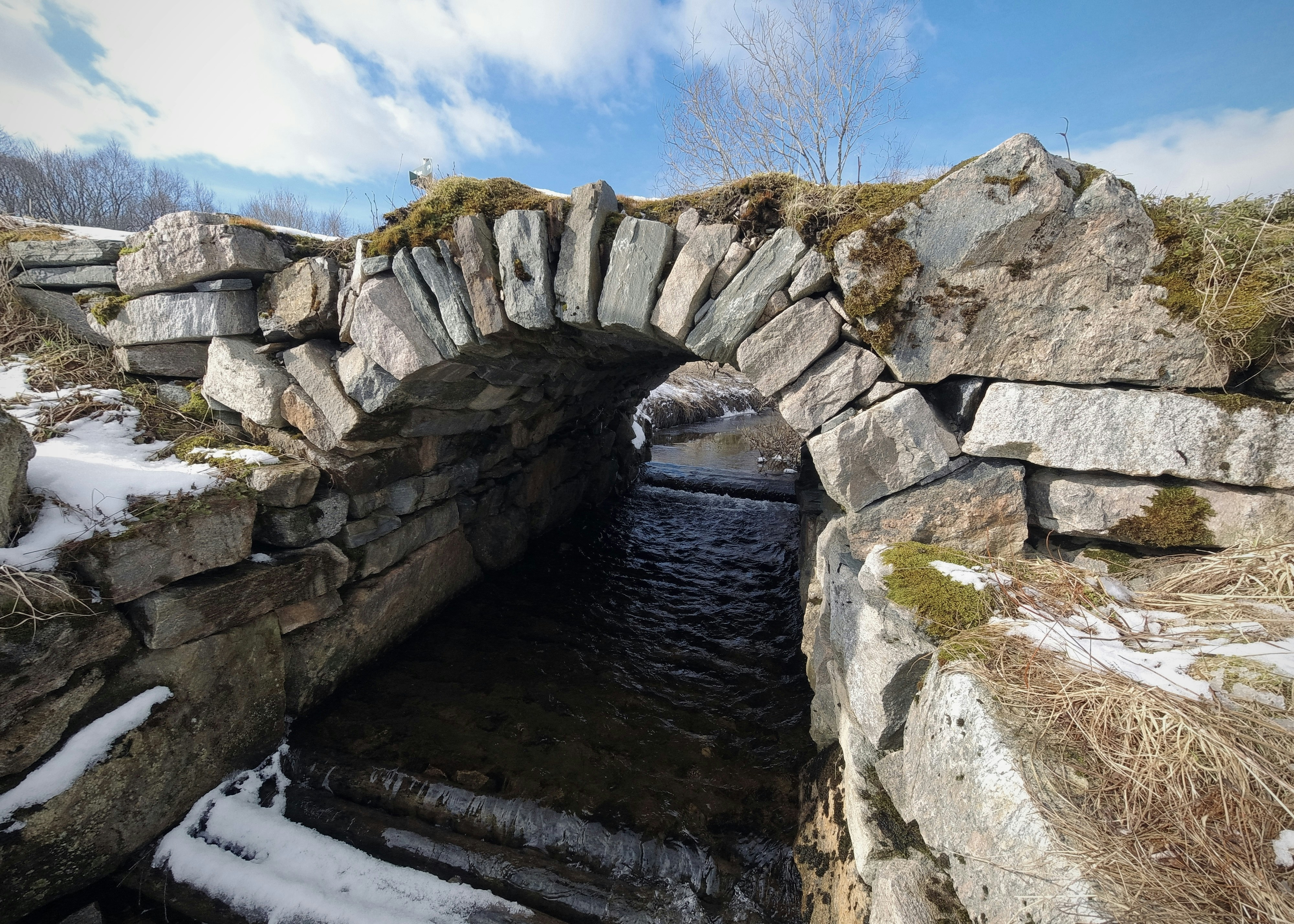 A stone bridge over a small stream in the snow photo – Free Rørvik ...