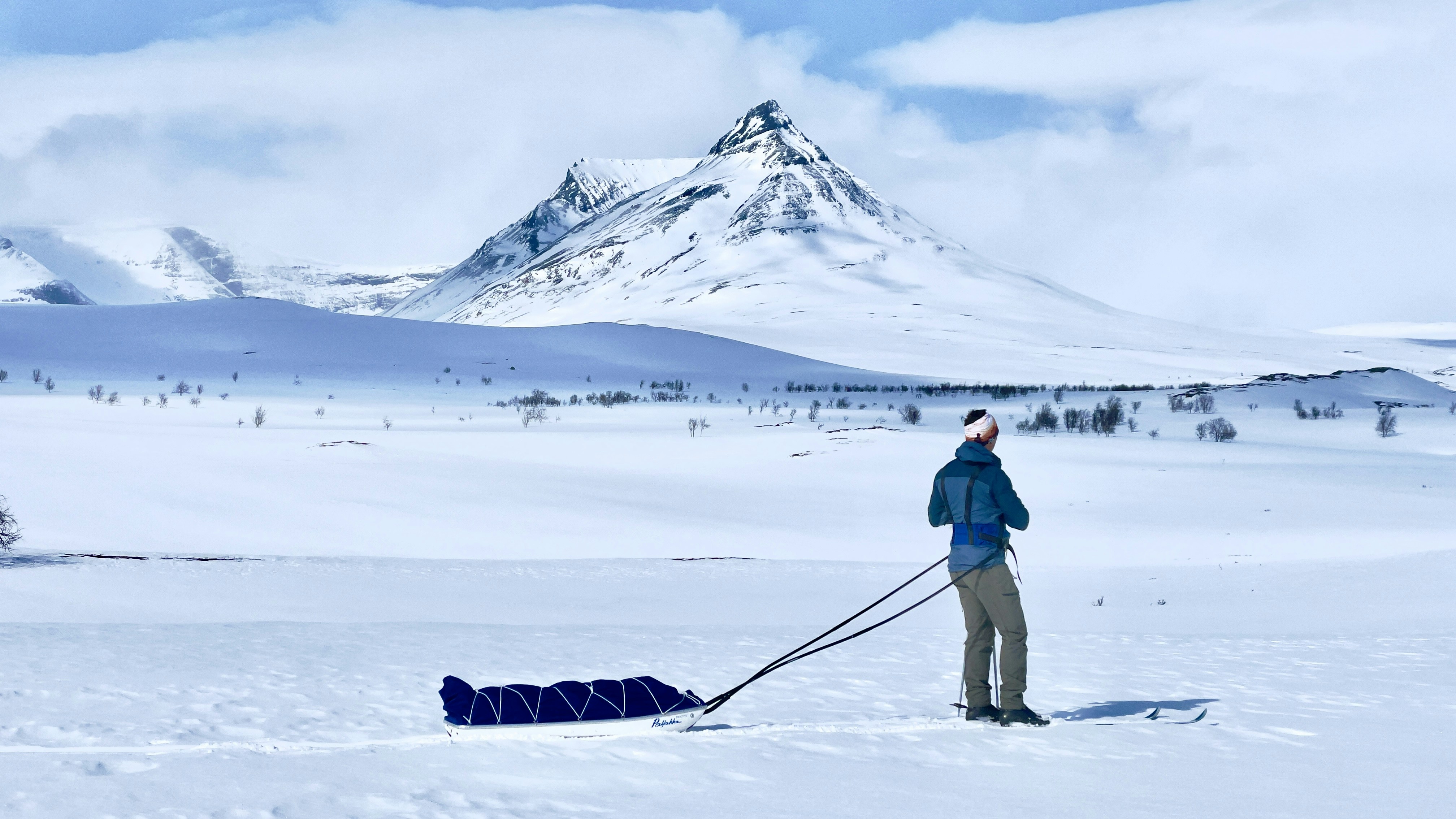 A person standing in the snow with a sled photo – Free Sweden Image on ...