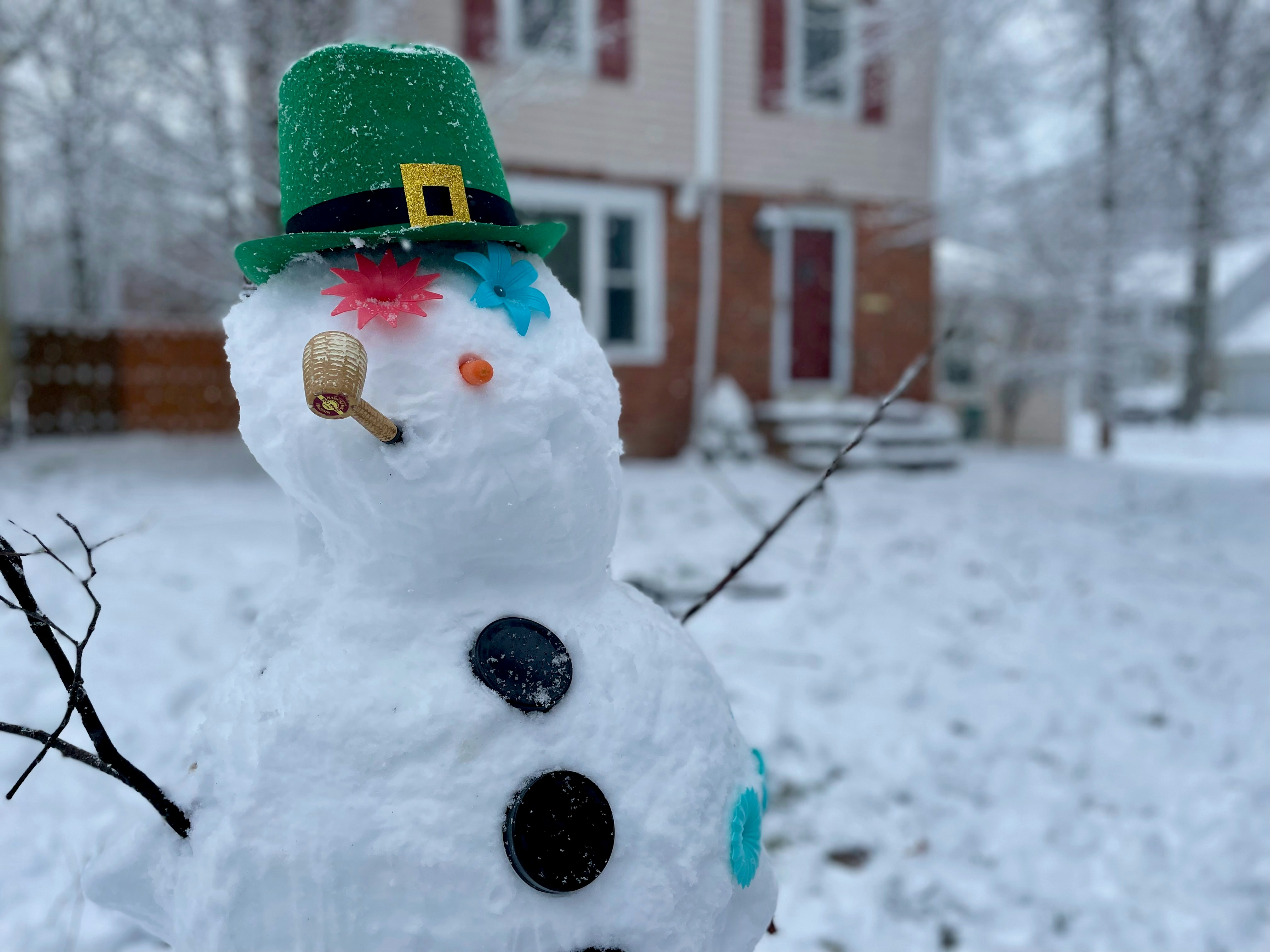 A snowman with a green hat is in the snow photo – Free Winter Image on ...