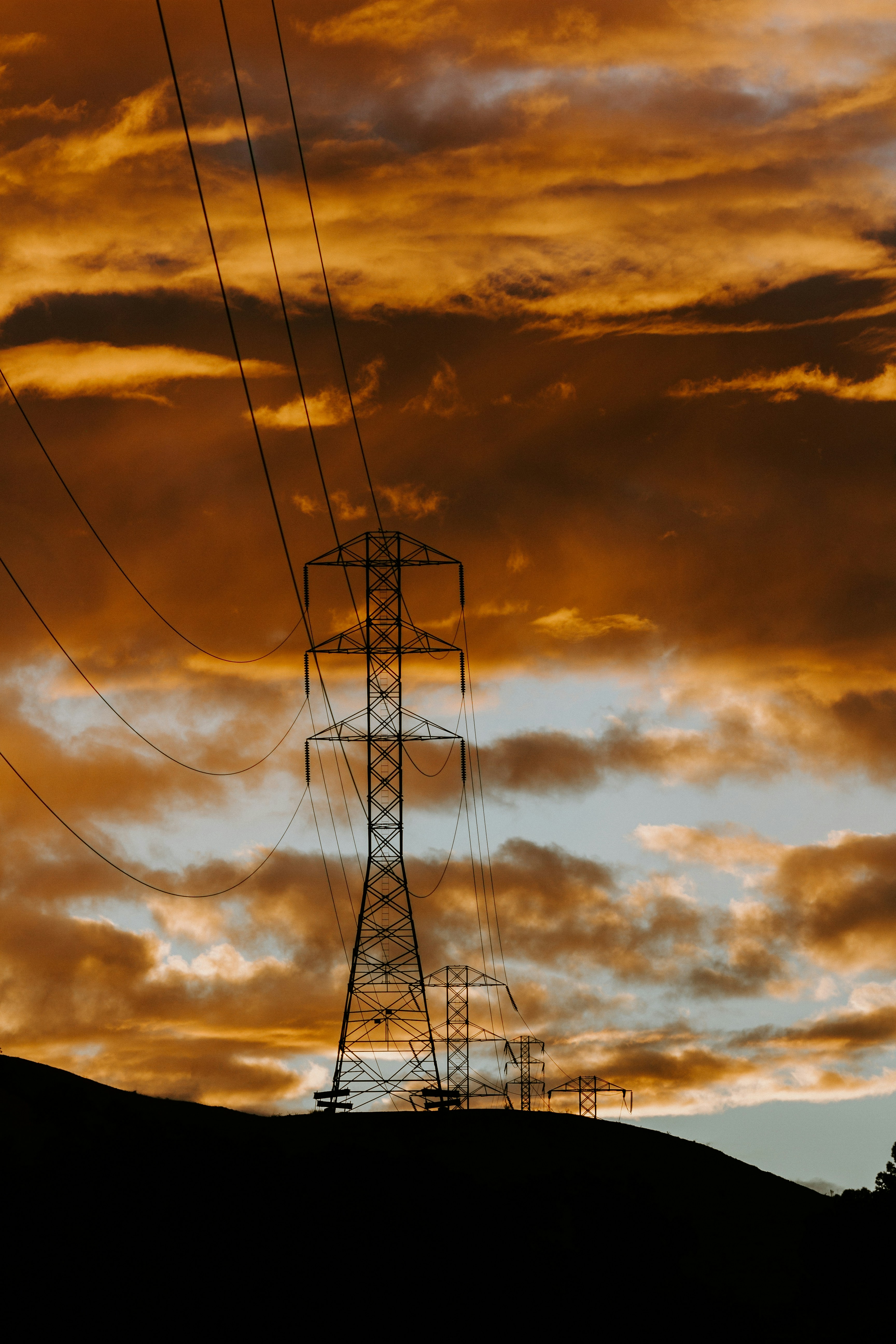 Lattice Giants at Dusk: Power Lines Carve a Fiery Sky