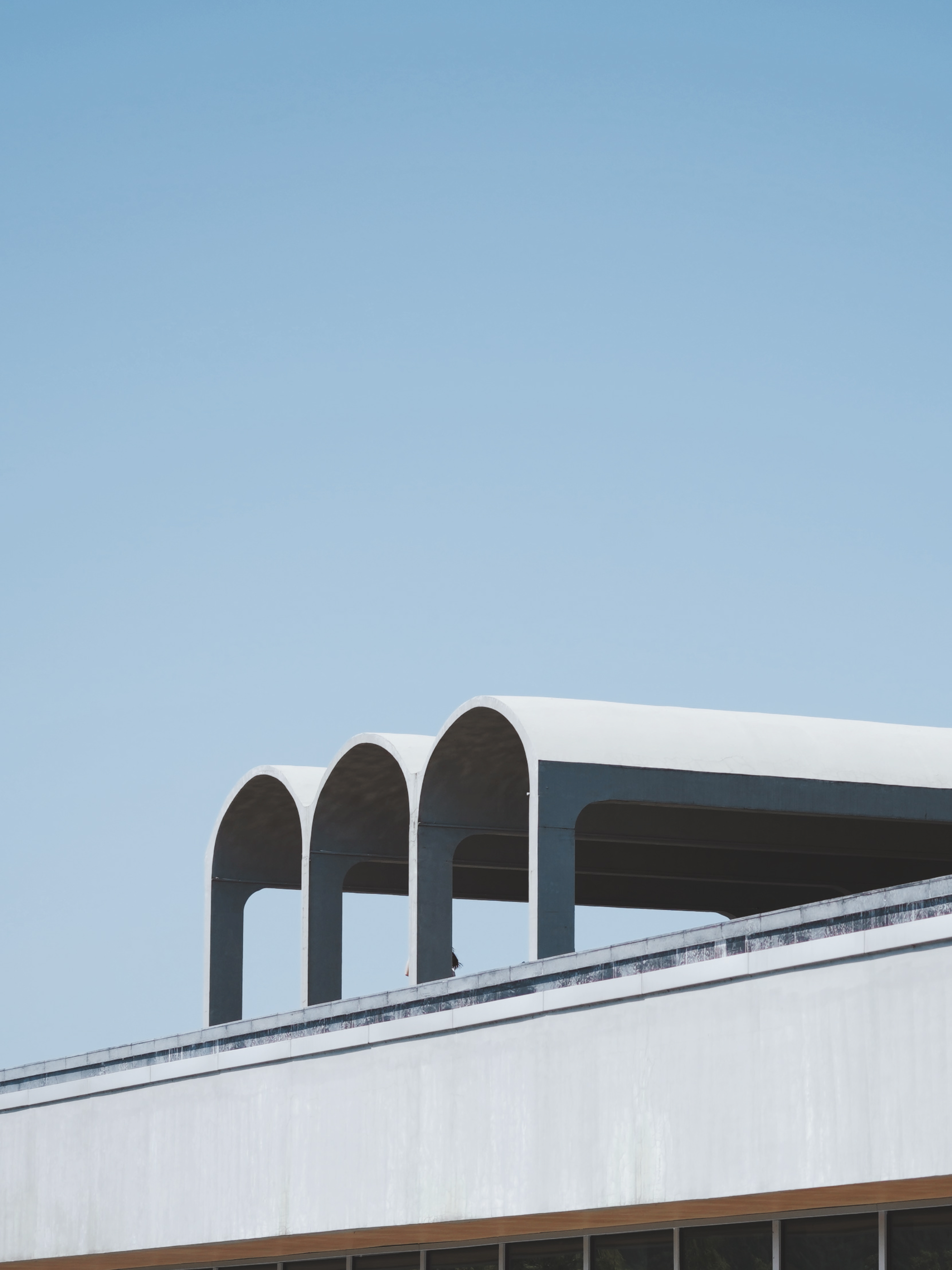 An airplane is flying in the sky over a building photo – Free Arch ...