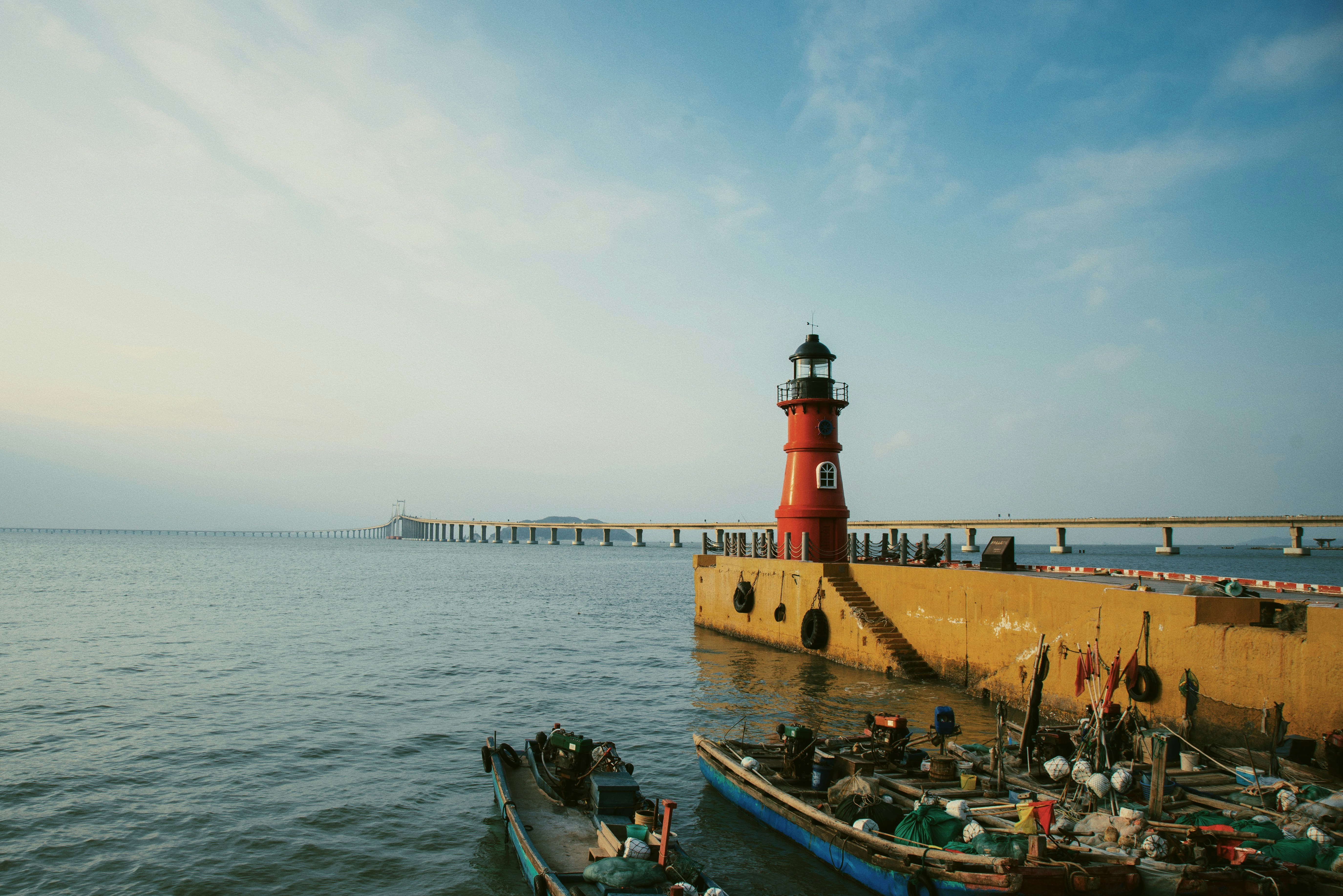 Crimson Beacon at the Pier's Edge: Boats Rest in Quiet Harbor