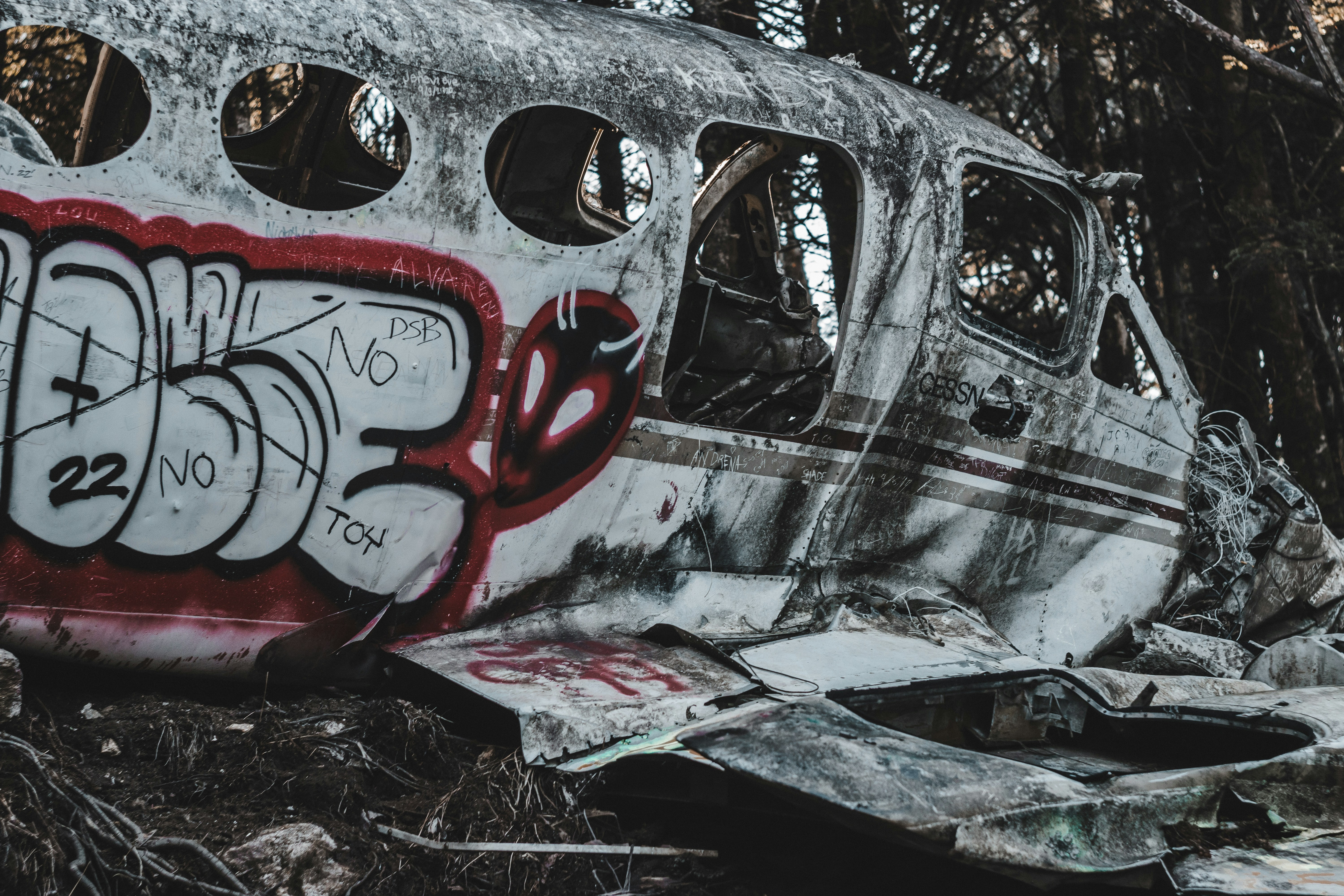 A run down plane with graffiti on the side of it photo – Free Metal ...