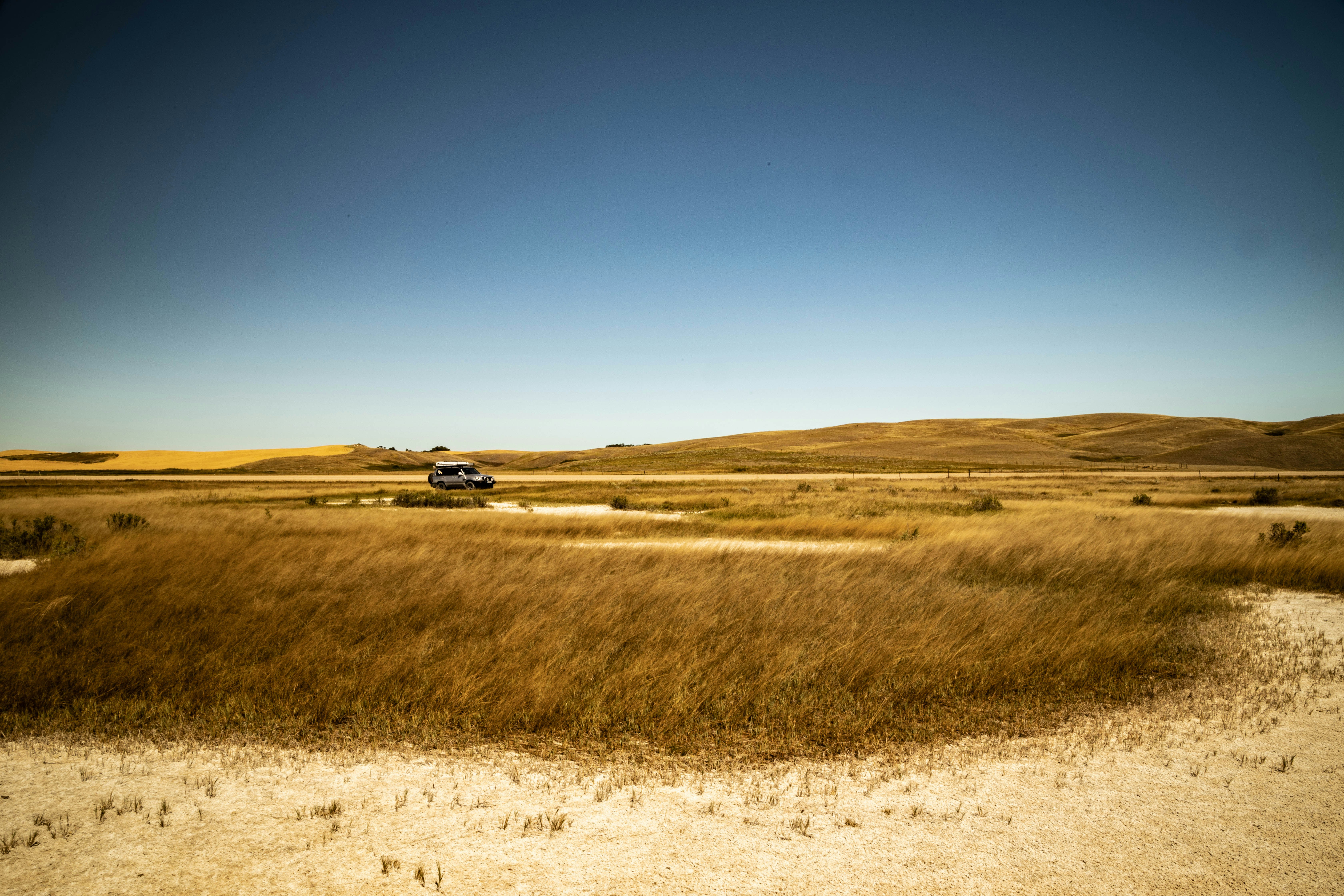 Desert Road Whisper: A Lone Pickup Crossing the Plain