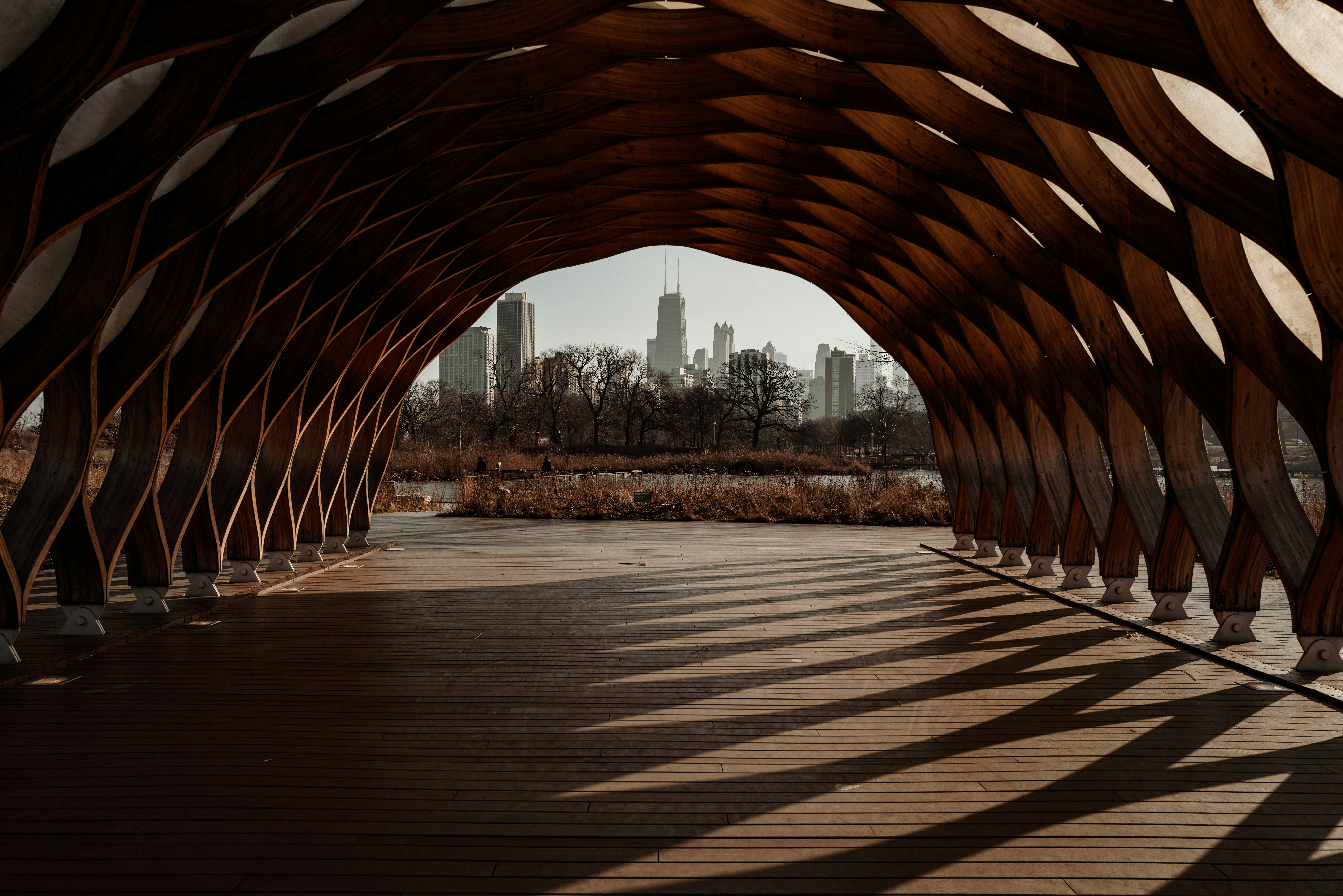 A large wooden structure with a city in the background photo – Free ...