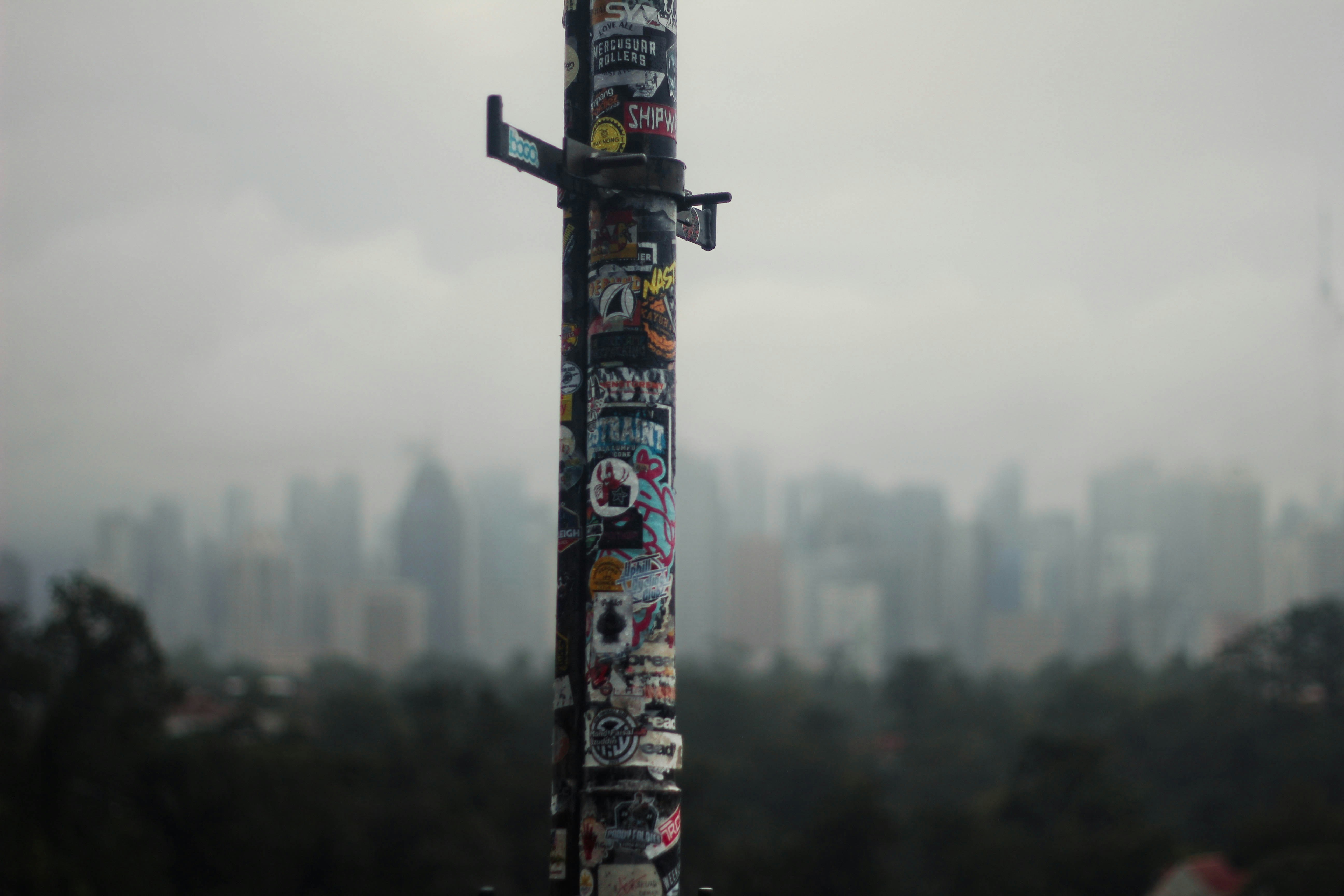 Stickered Sentinel: A Pole in Sharp Focus Against a Hazy Skyline