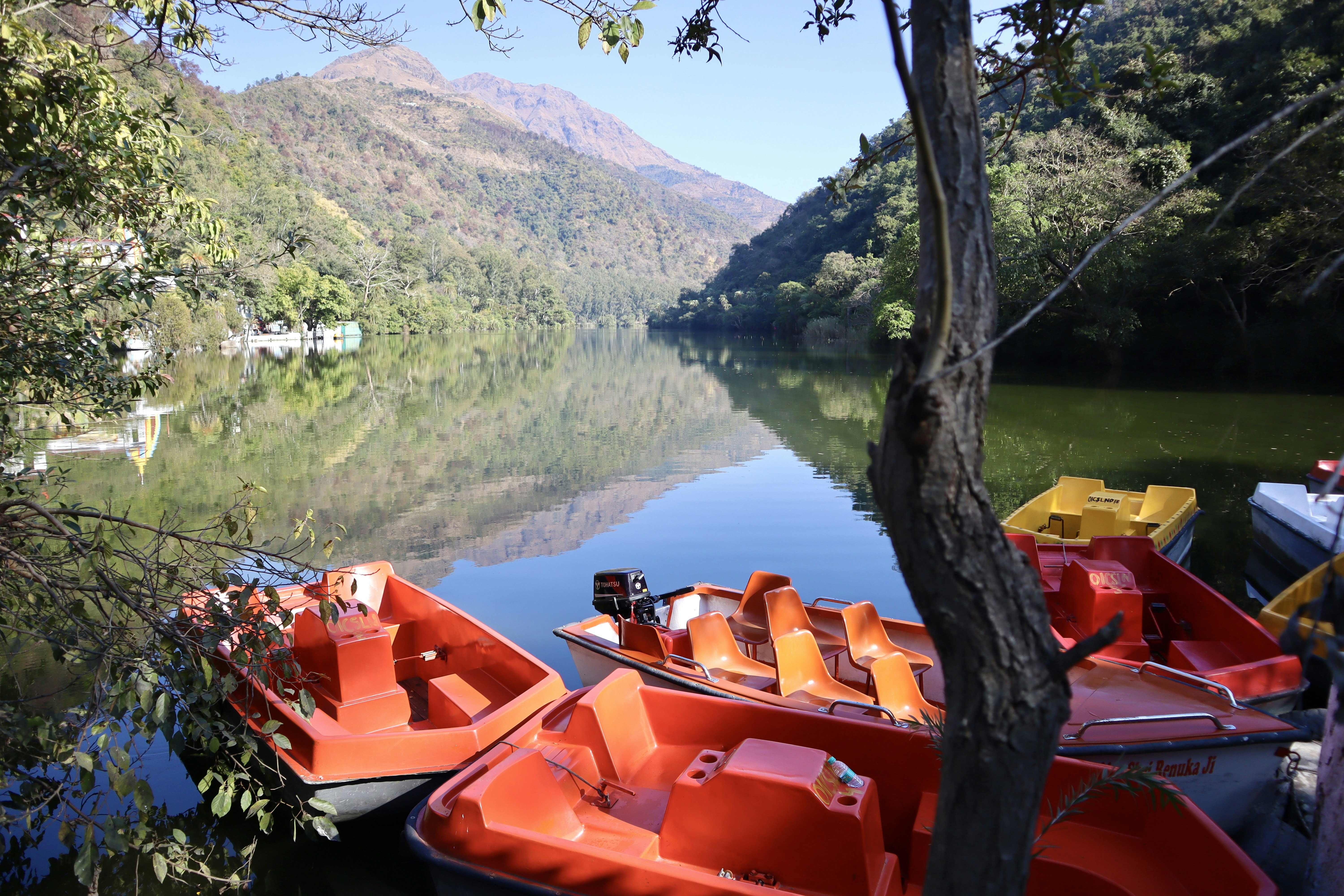 Red Rowboats Fringing a Mirror-Still Alpine Lake