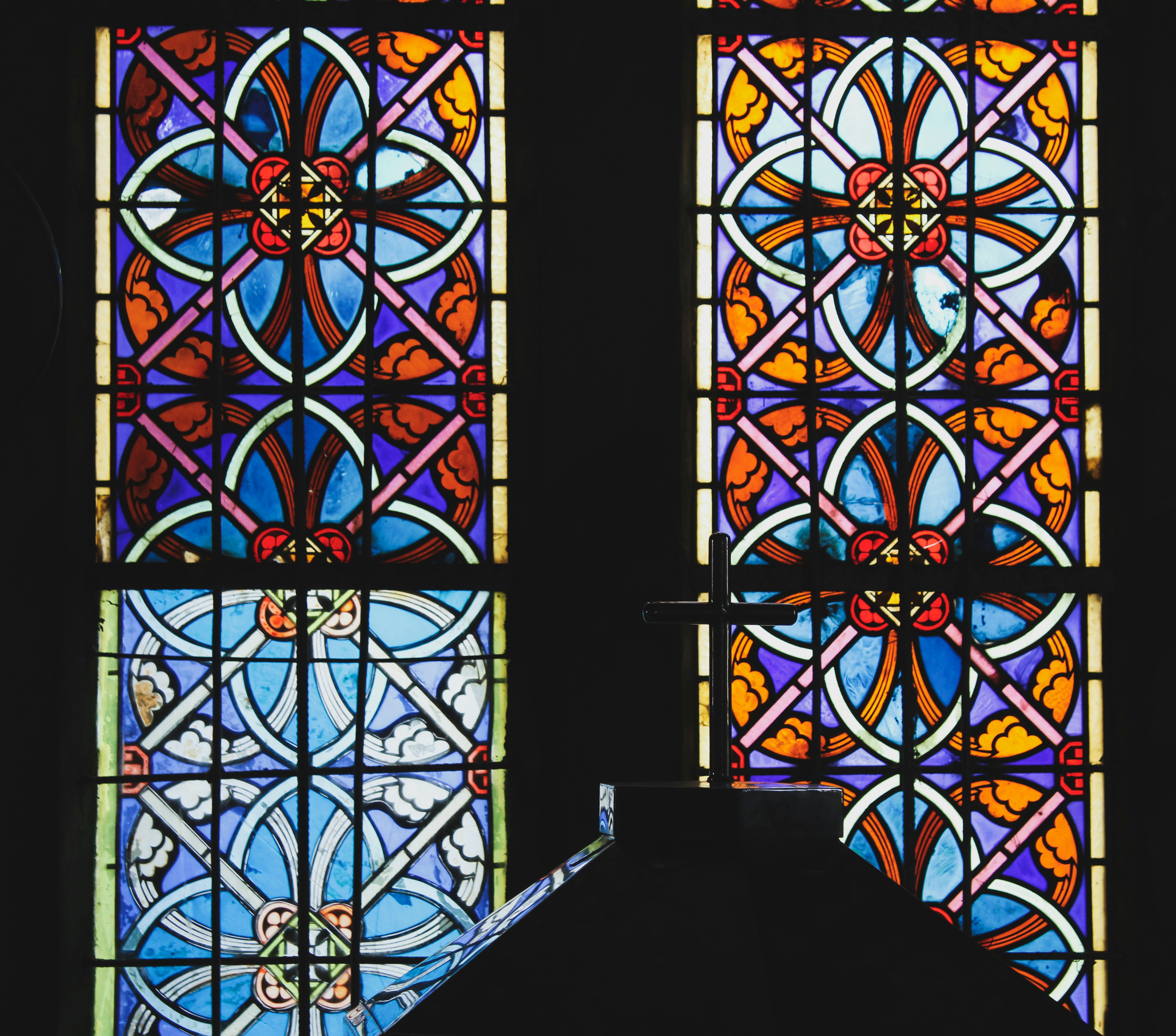two stained glass windows in a dark room