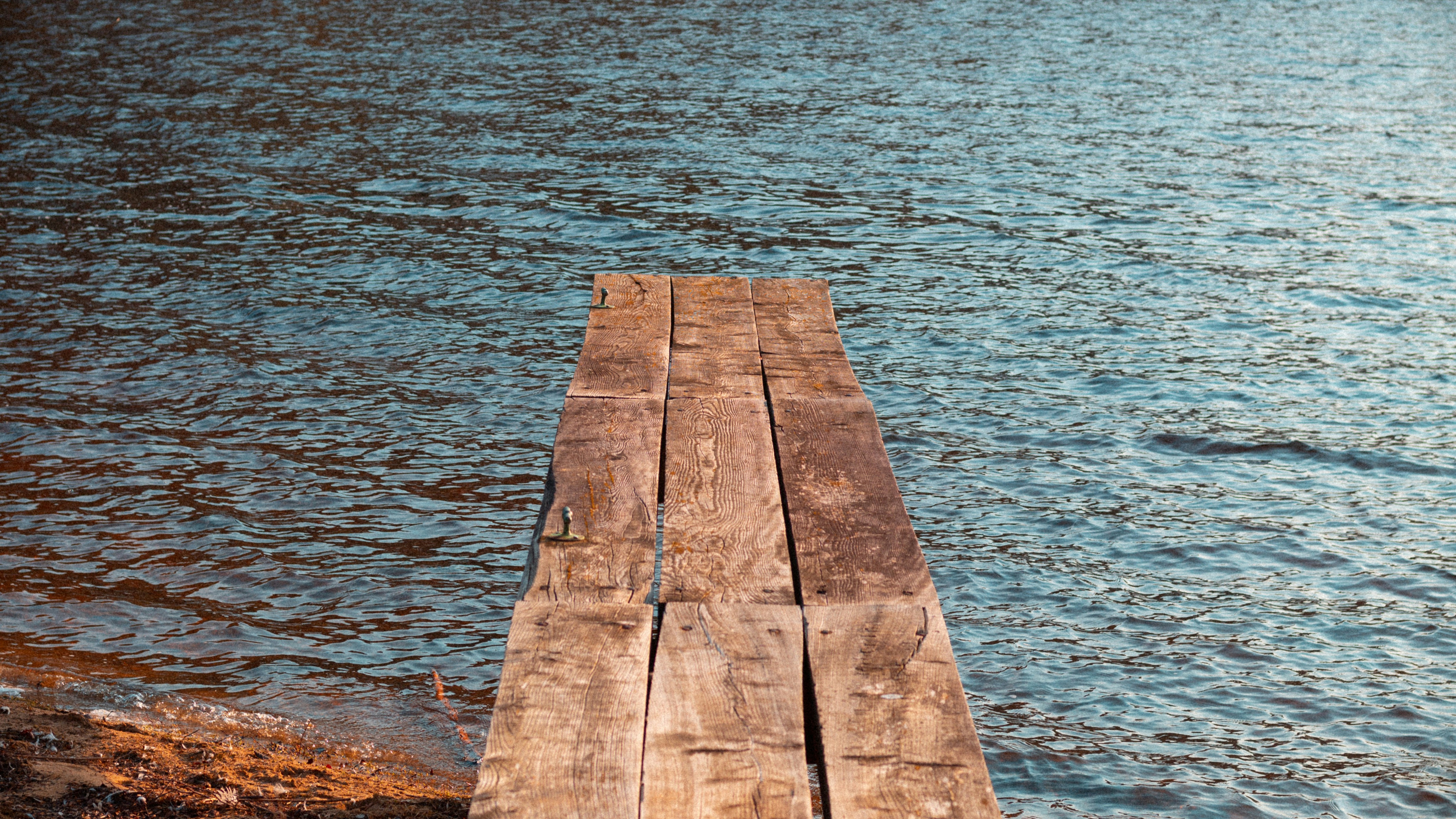 A wooden plank leads out to the water.