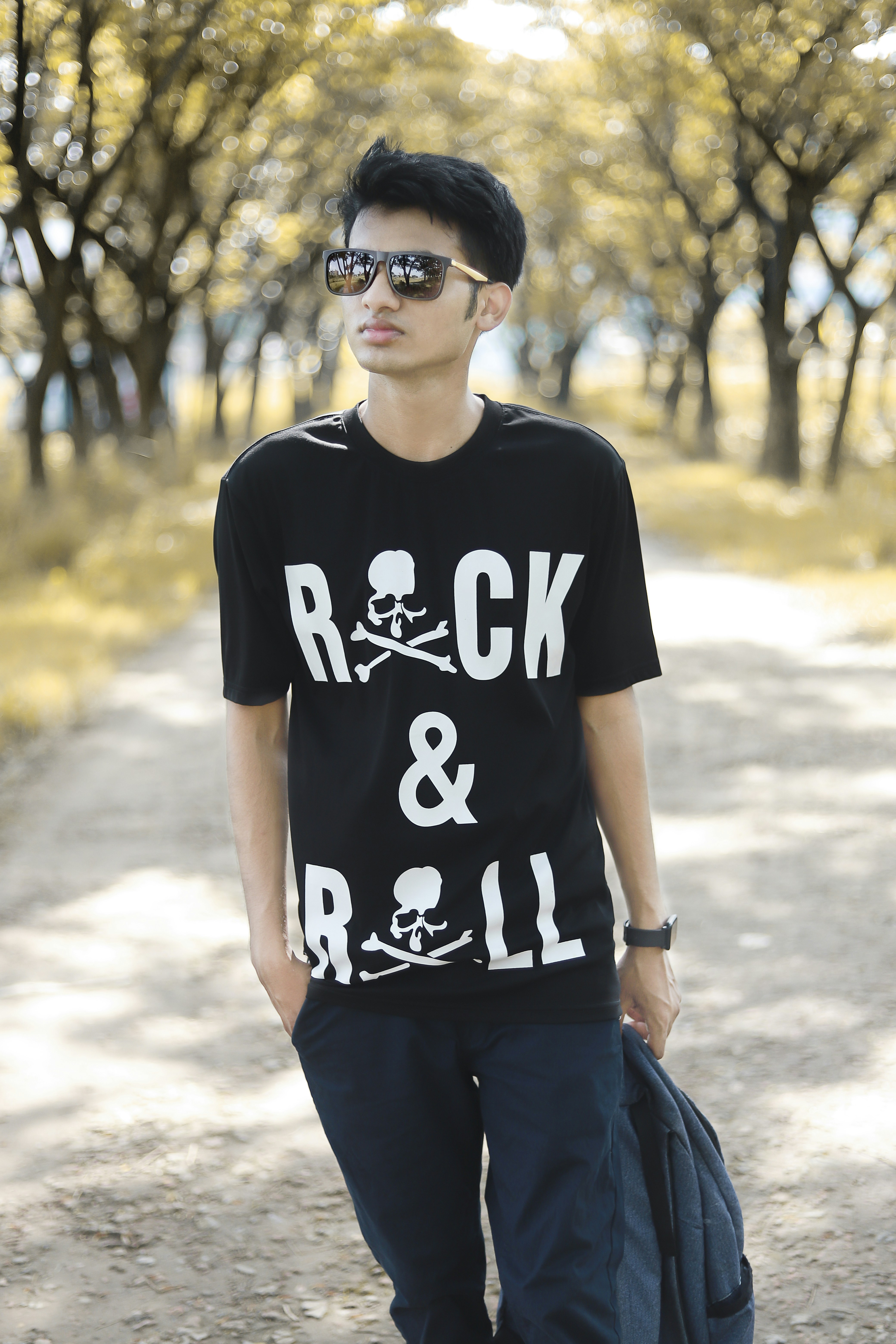a young man wearing sunglasses and a rock and roll t - shirt