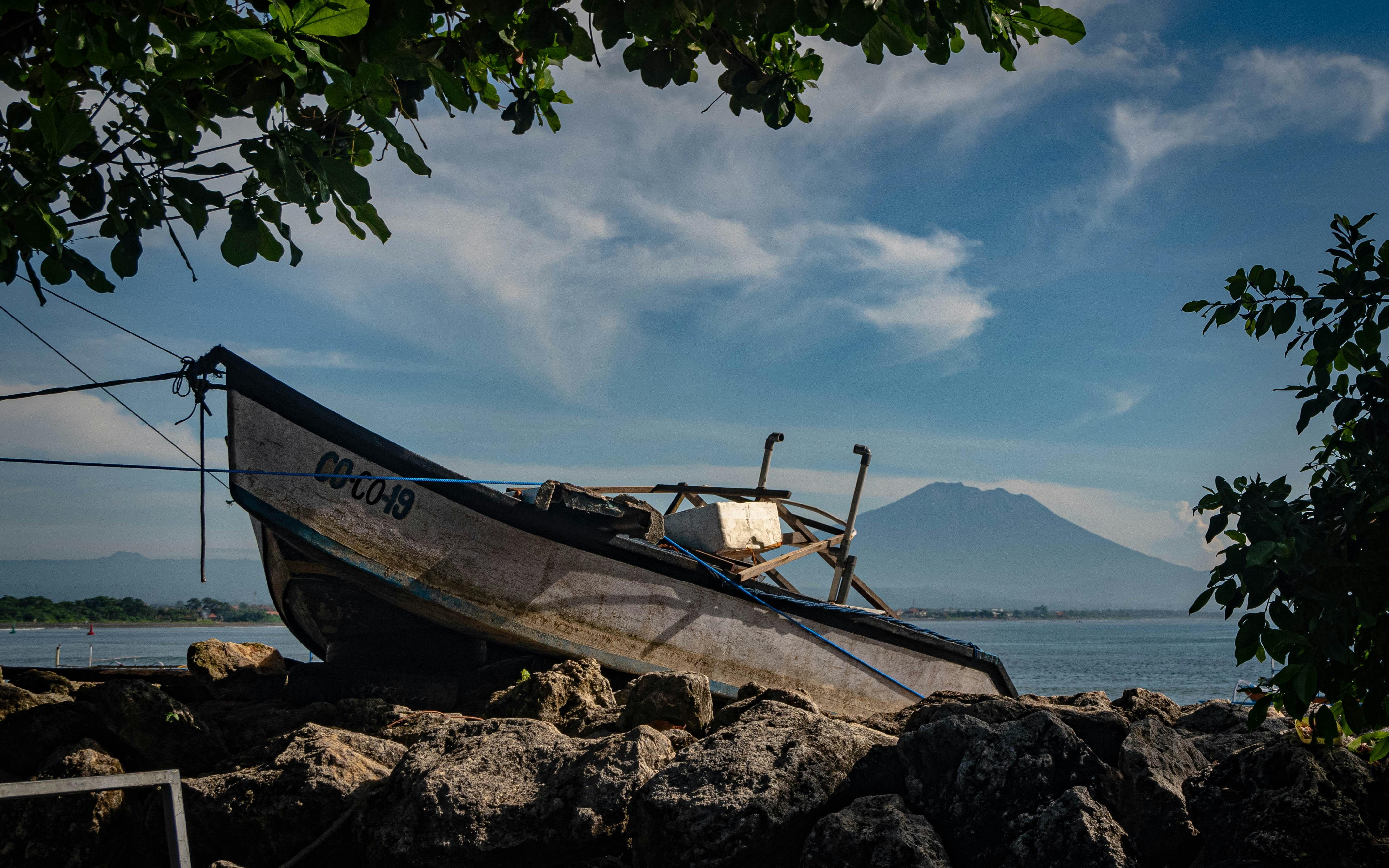 Weathered Boat on a Rocky Shore Beneath a Quiet Coastal Sky