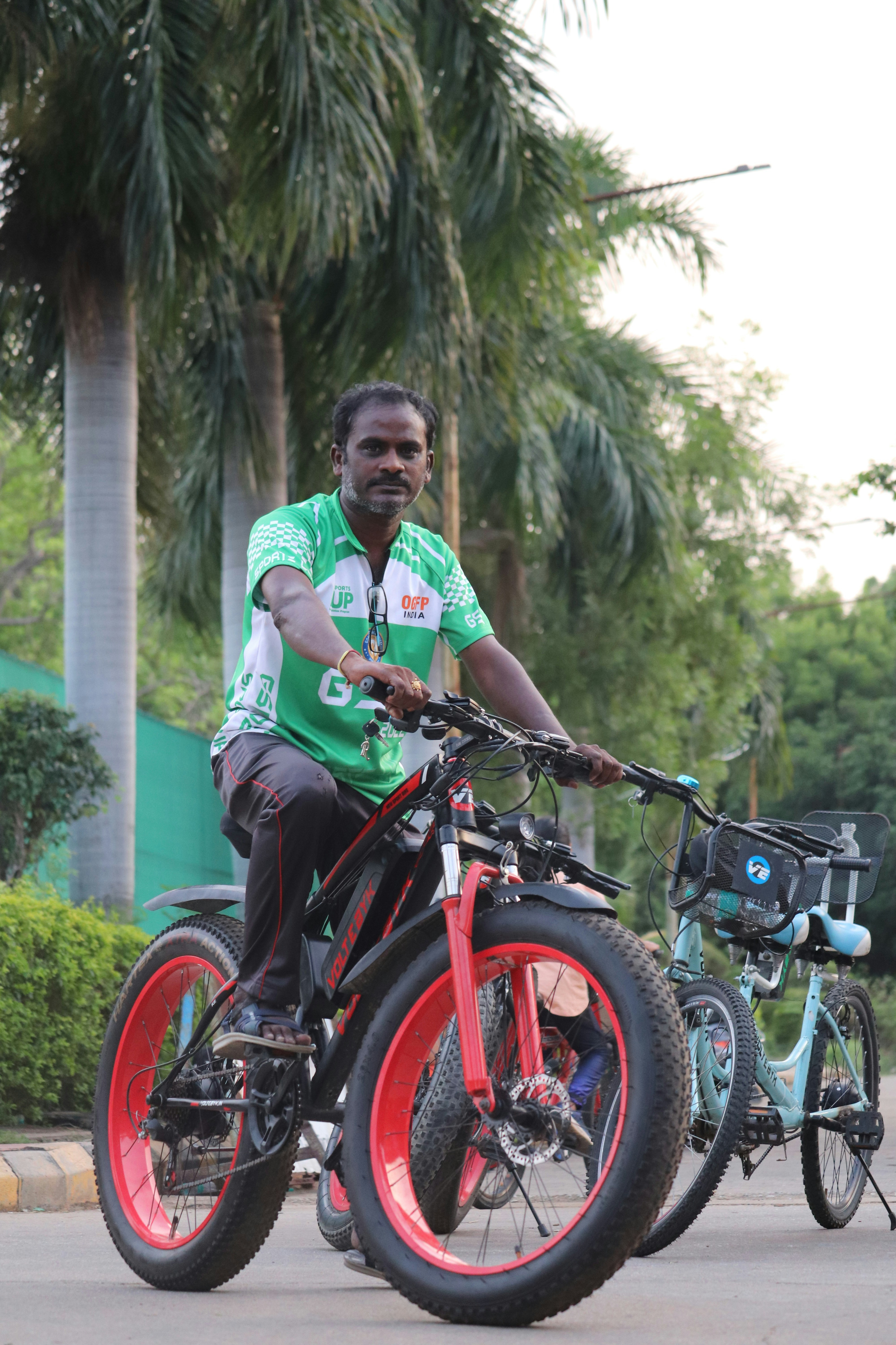 Cyclist on a Red-Wheeled Fat-Tire Bike Amid Palm Trees
