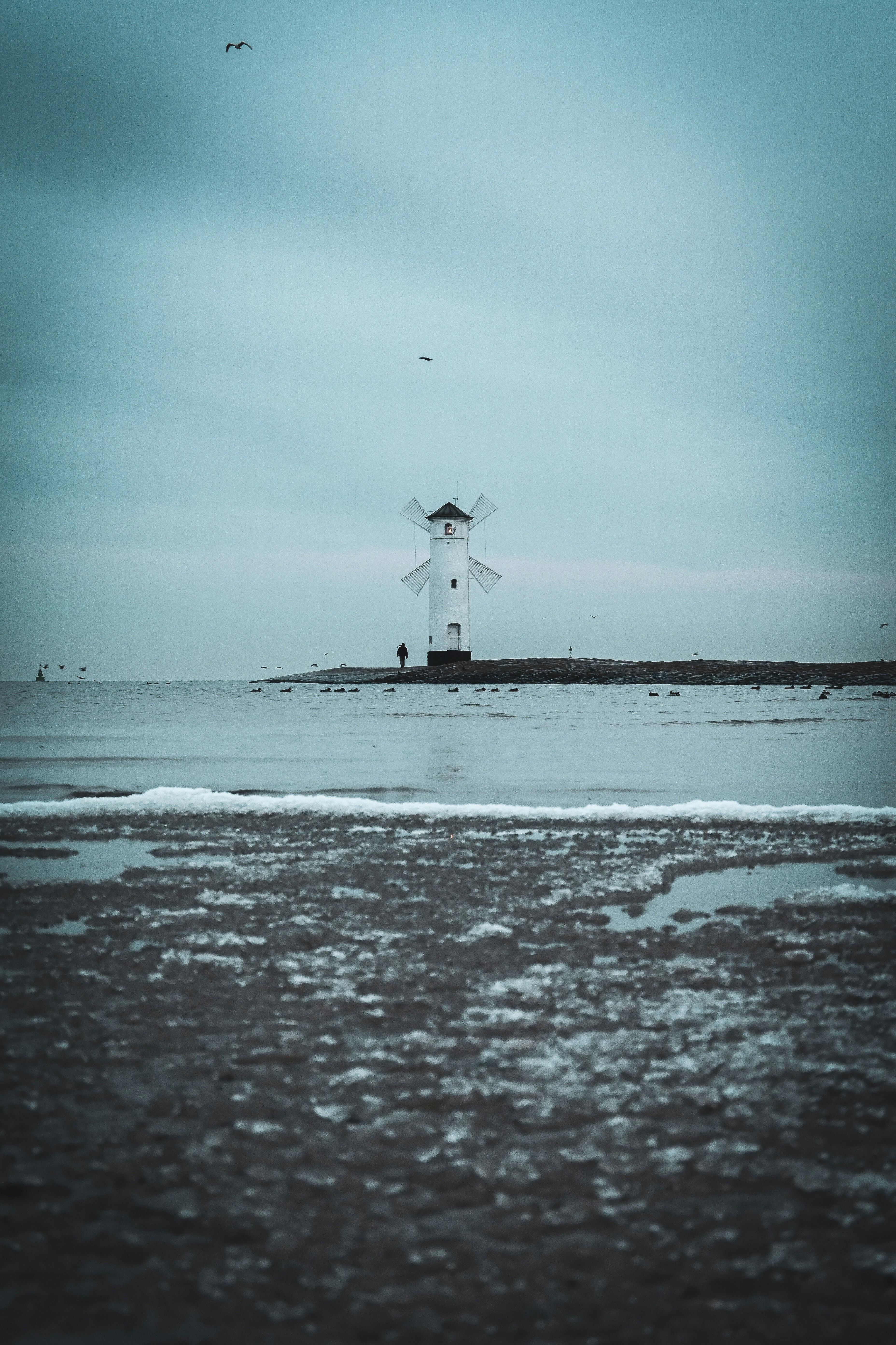 Azure Drift: A lone lighthouse guards a quiet shoreline