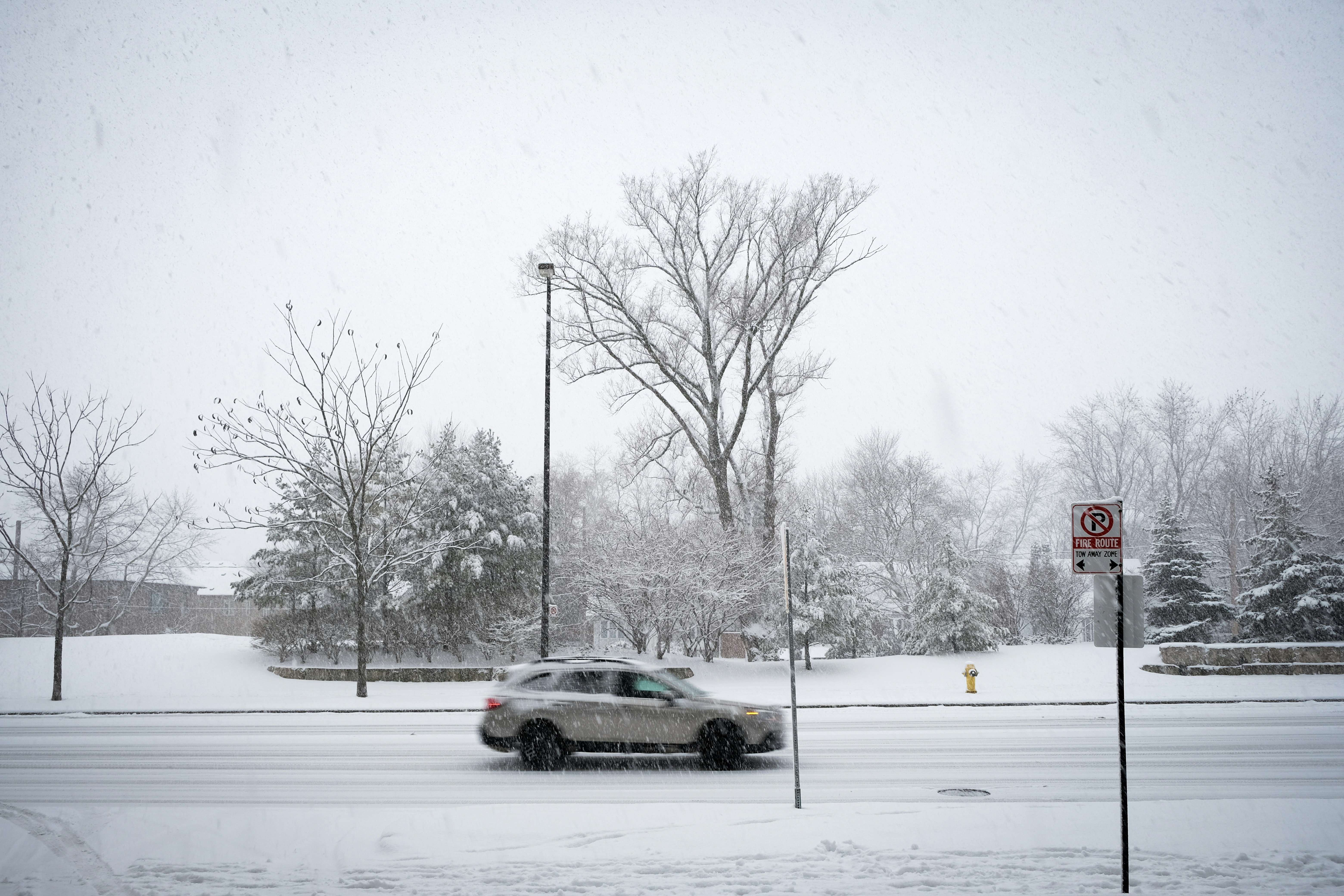 Midwinter Drift: A Gray SUV Navigates a Quiet, Snow-Blanketed Street
