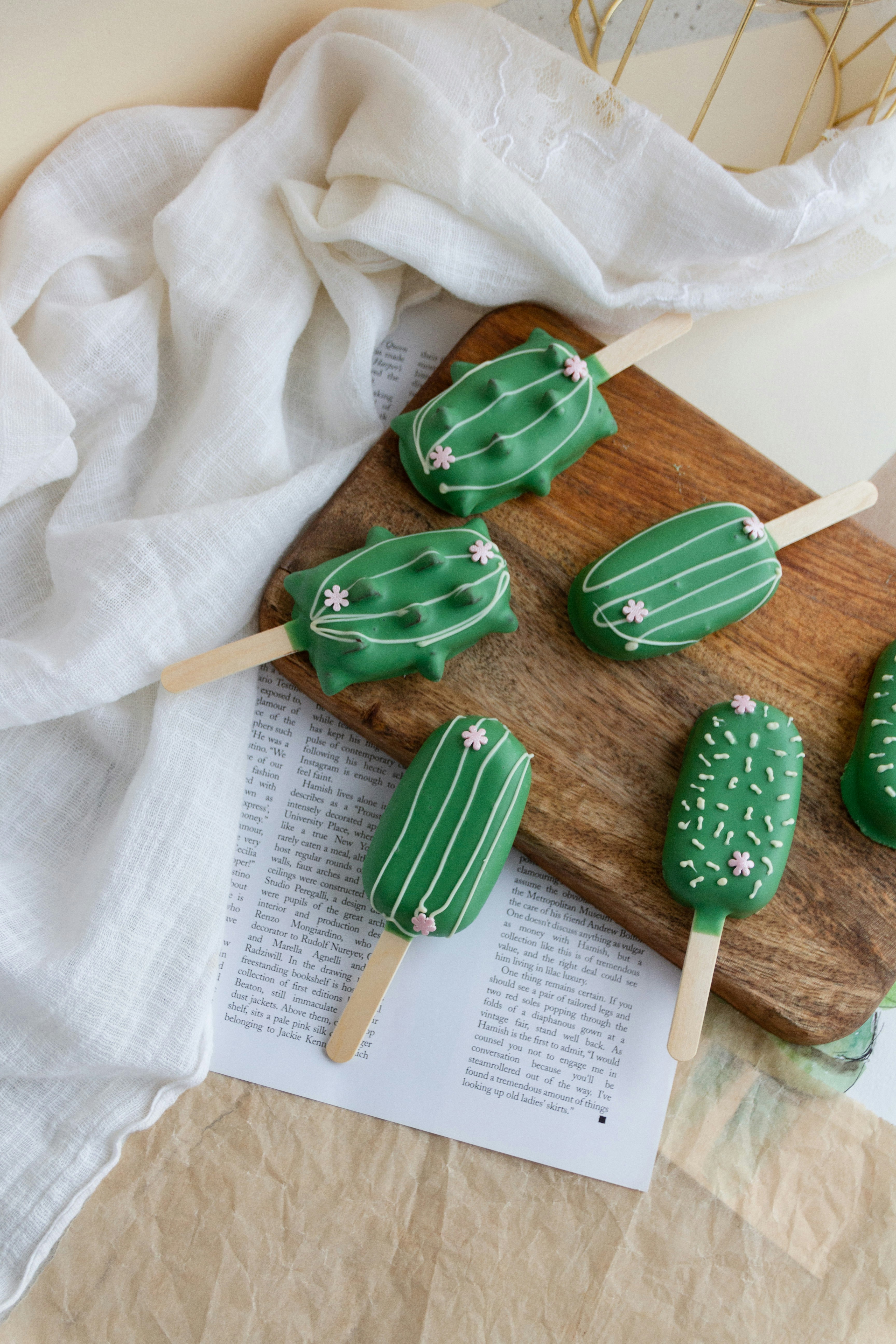 A wooden cutting board topped with green cactus lollipops photo – Free ...