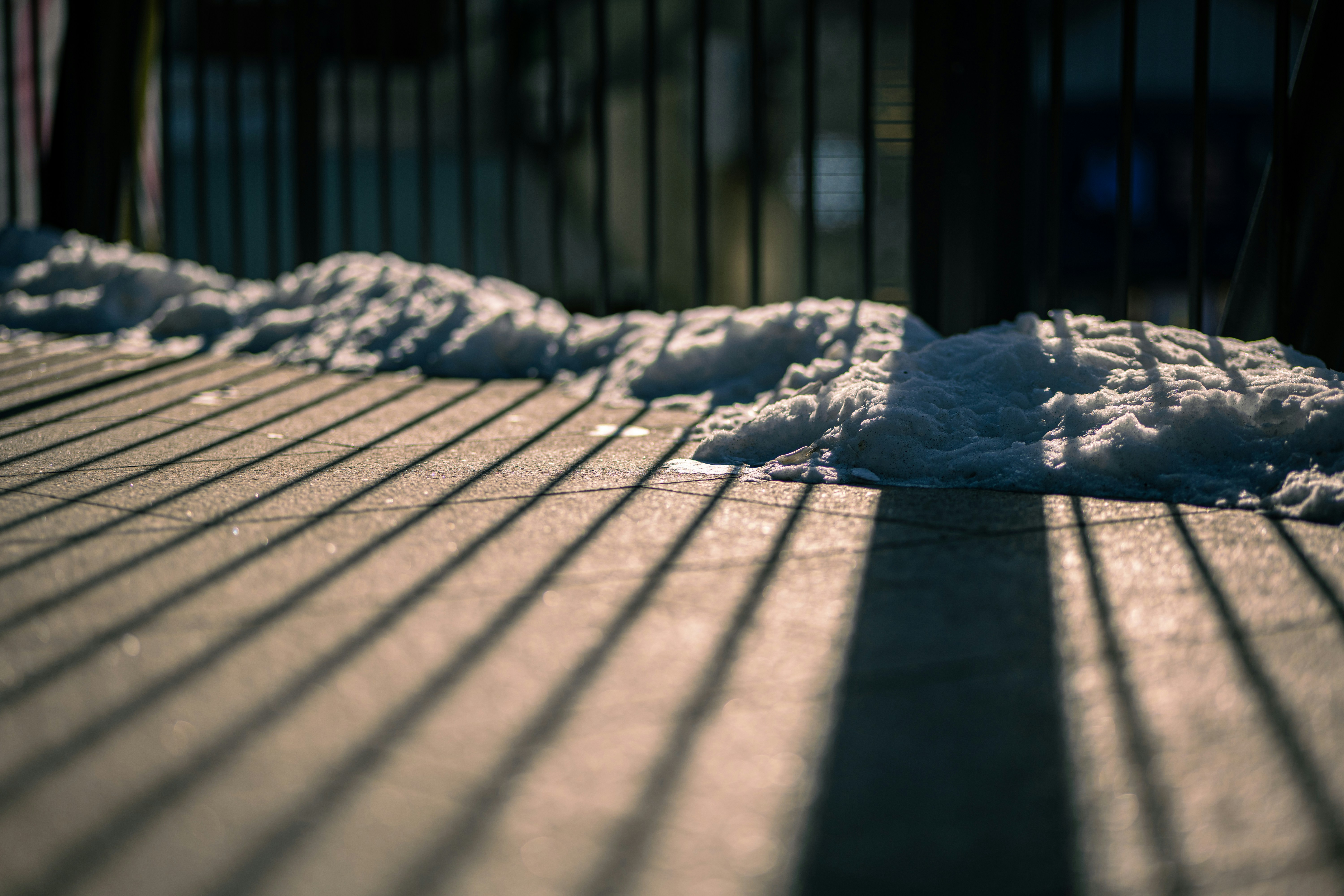 the shadow of a fence on the ground