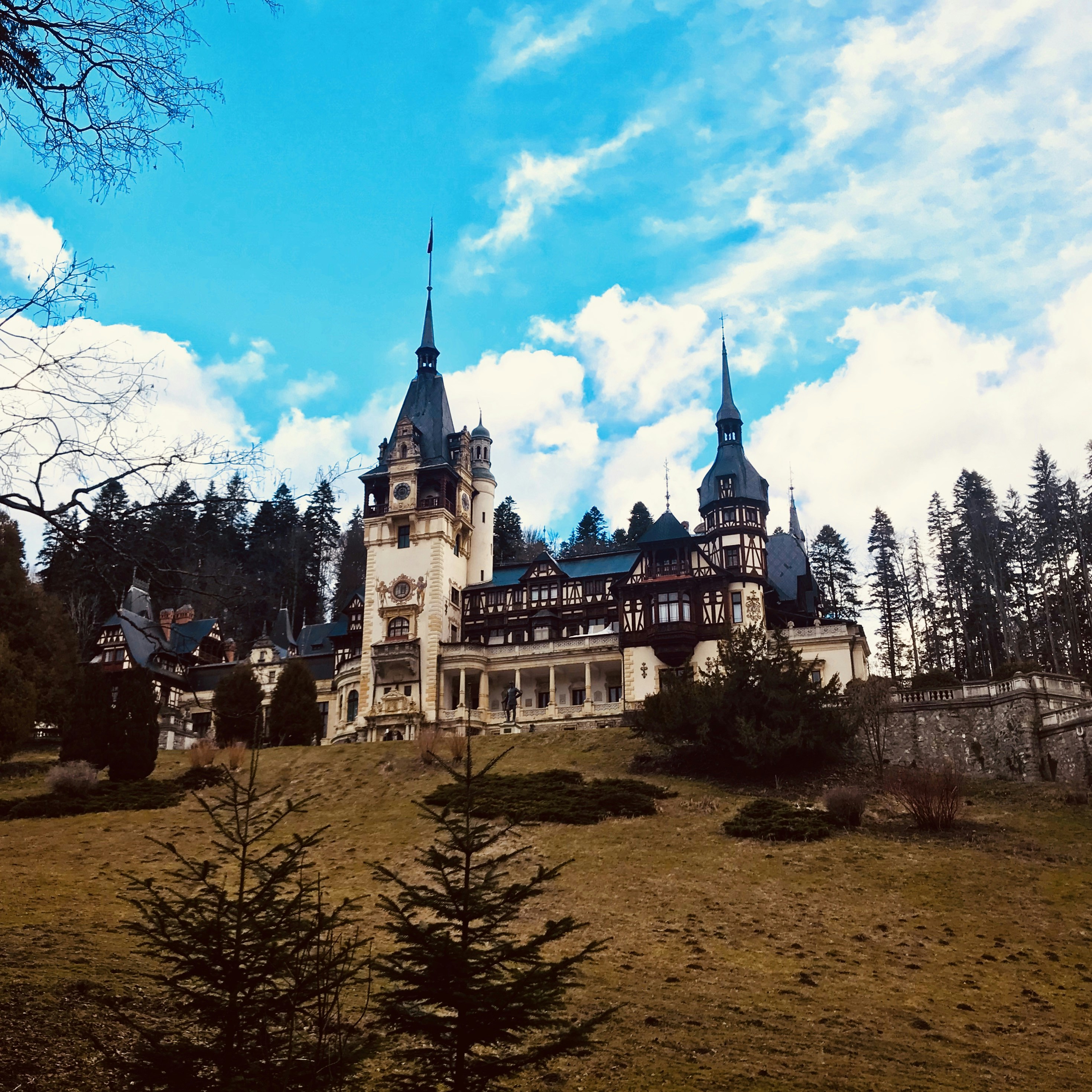 A large white castle sitting on top of a lush green hillside photo ...