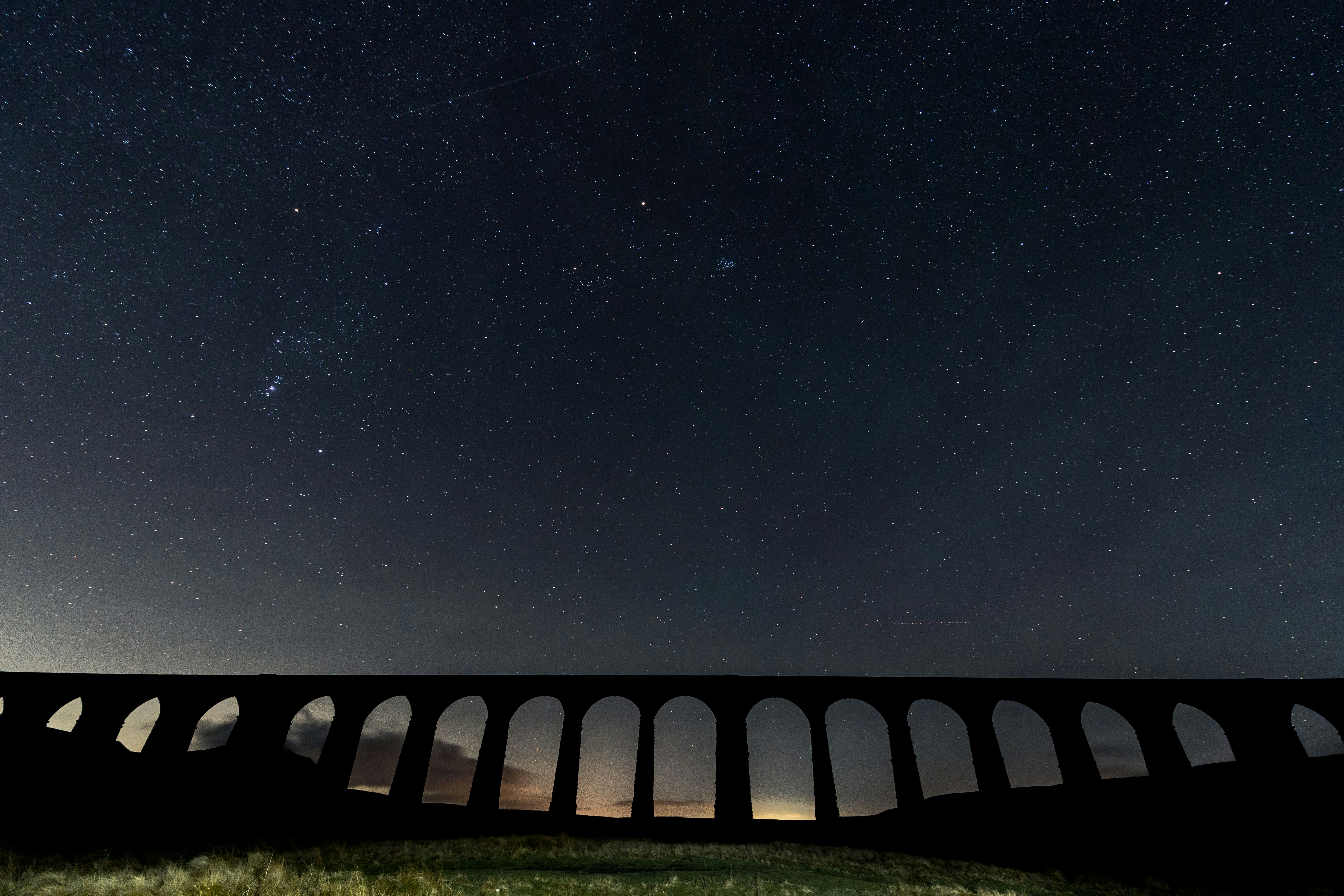 A night sky with stars above a bridge photo – Free Space Image on Unsplash