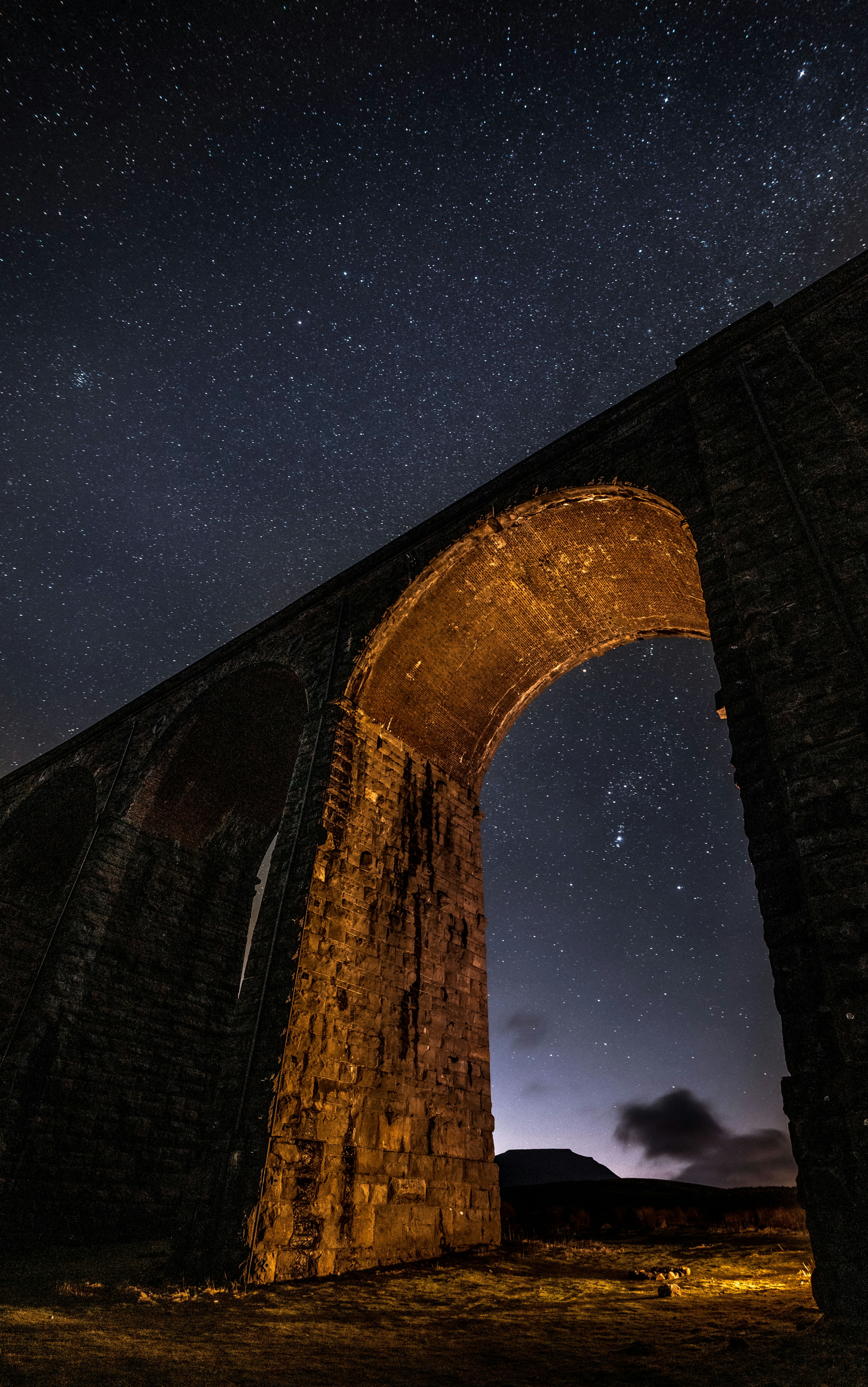 A stone bridge with a sky full of stars in the background photo – Free ...