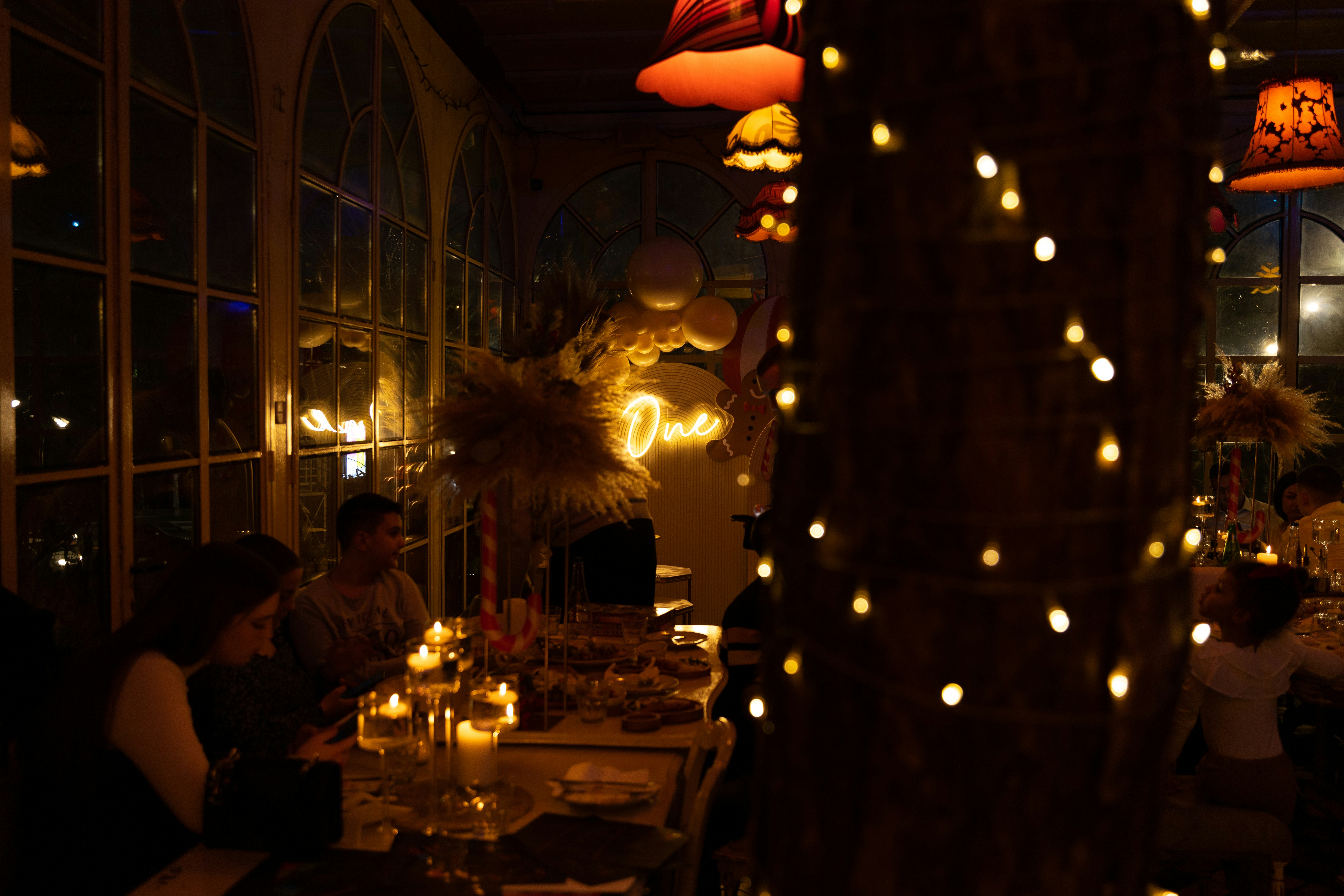 Neon Glow Behind Candlelit Tables in a Cozy Restaurant