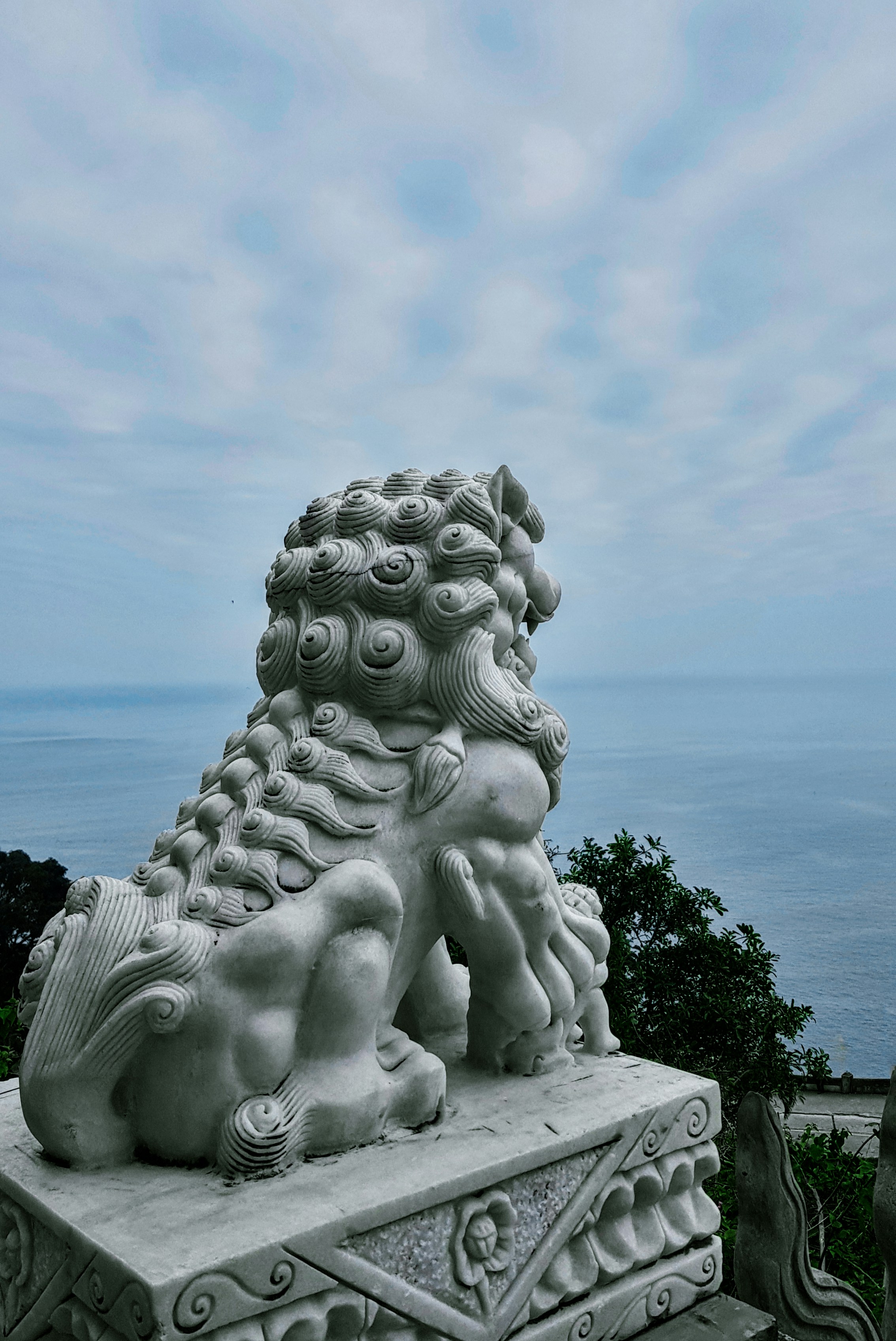 A statue of a lion sitting on top of a stone slab photo – Free Art ...