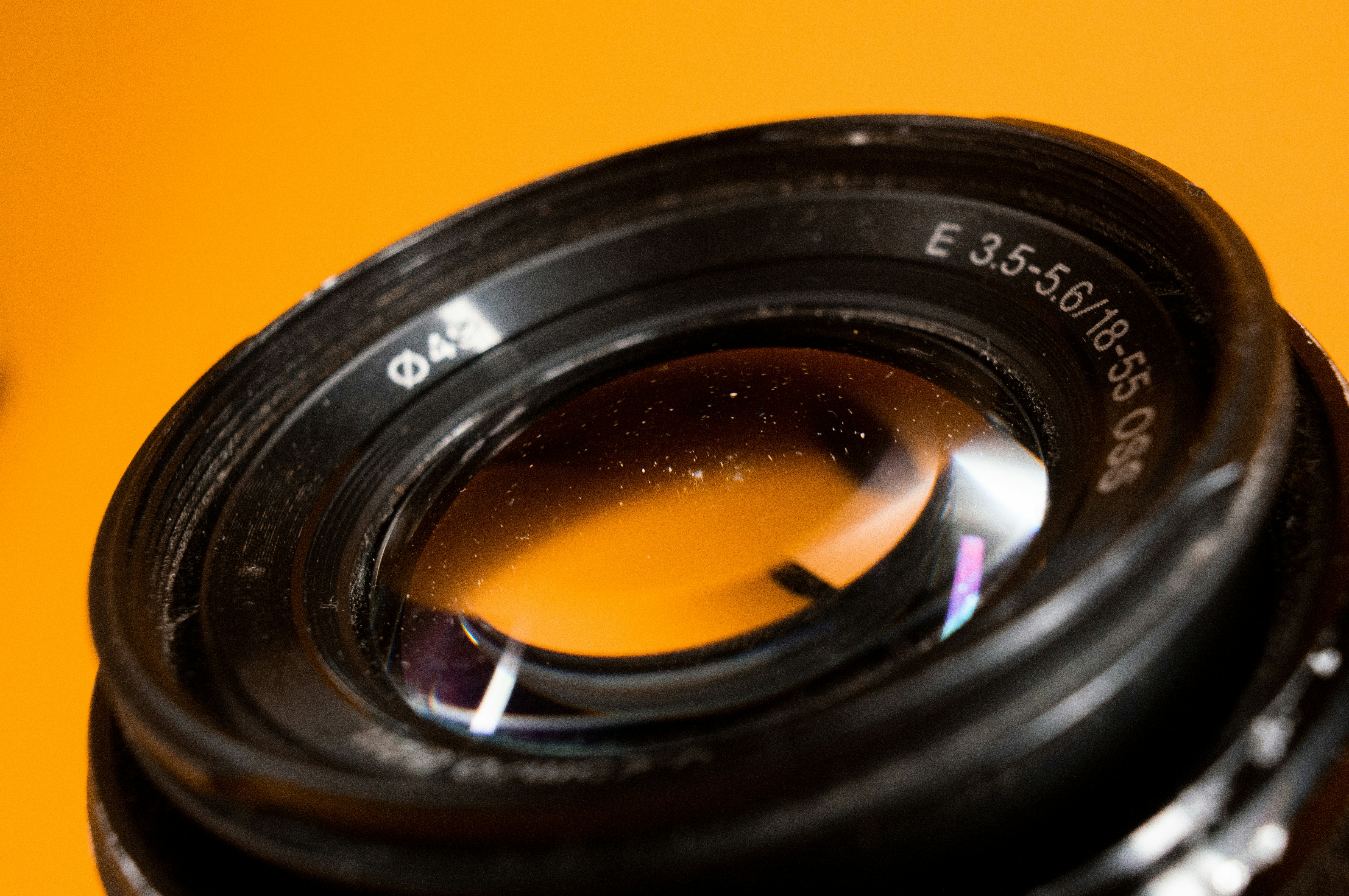 Close-Up of a Vintage Lens Against a Vibrant Orange Backdrop