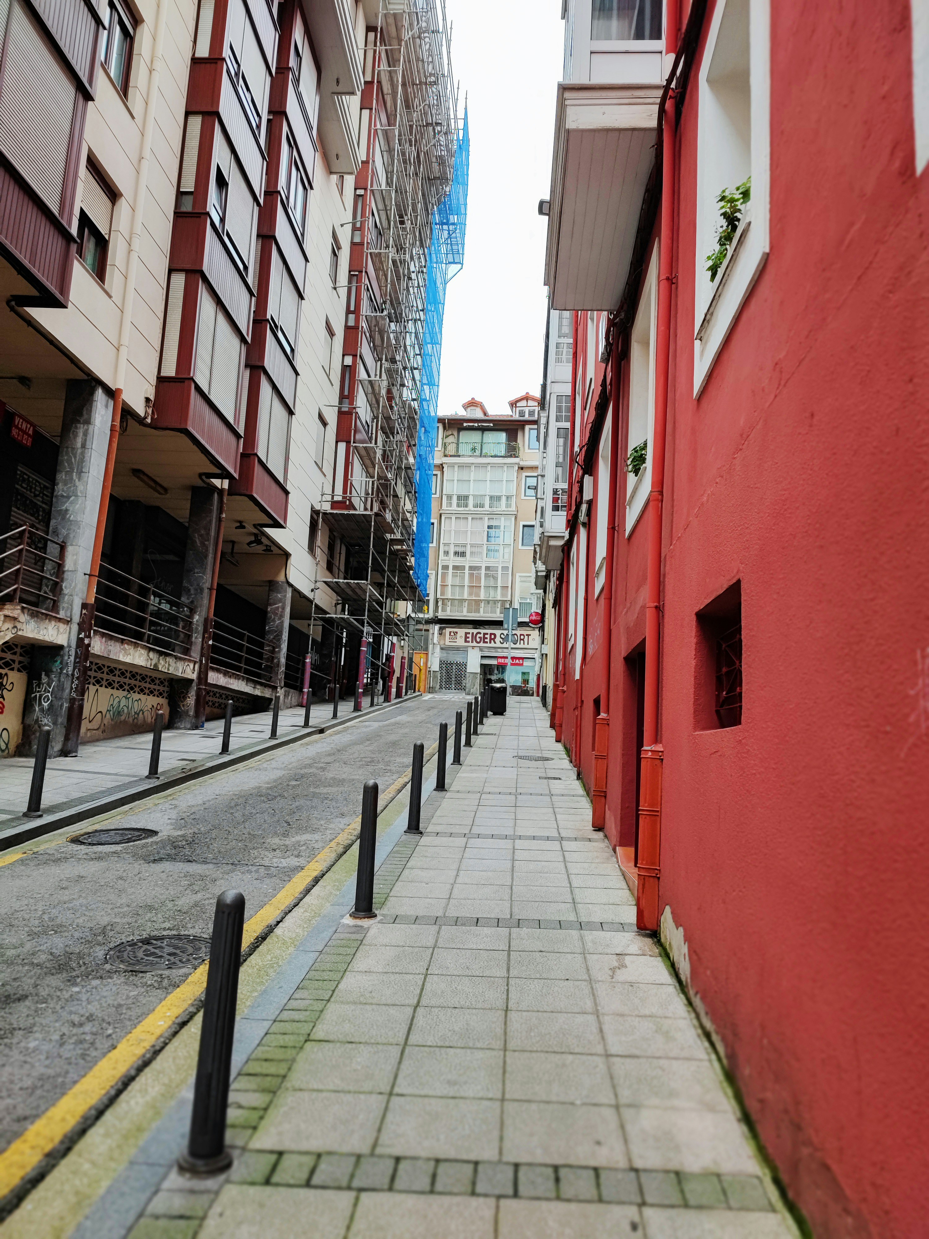 A narrow city street lined with tall buildings photo – Free Urban Image ...