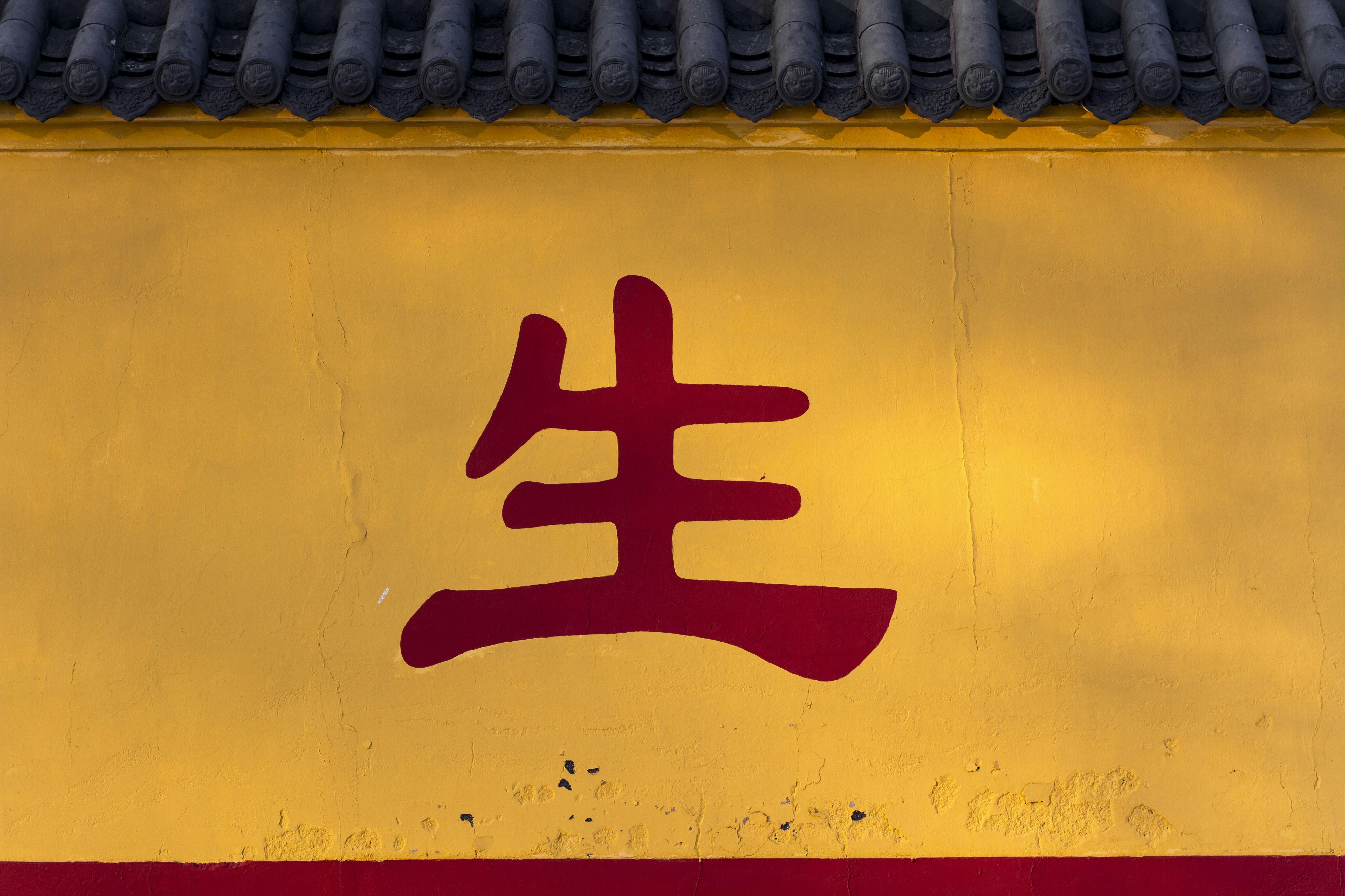 Golden Wall with Red Character: The Centerpiece of a Quiet Facade