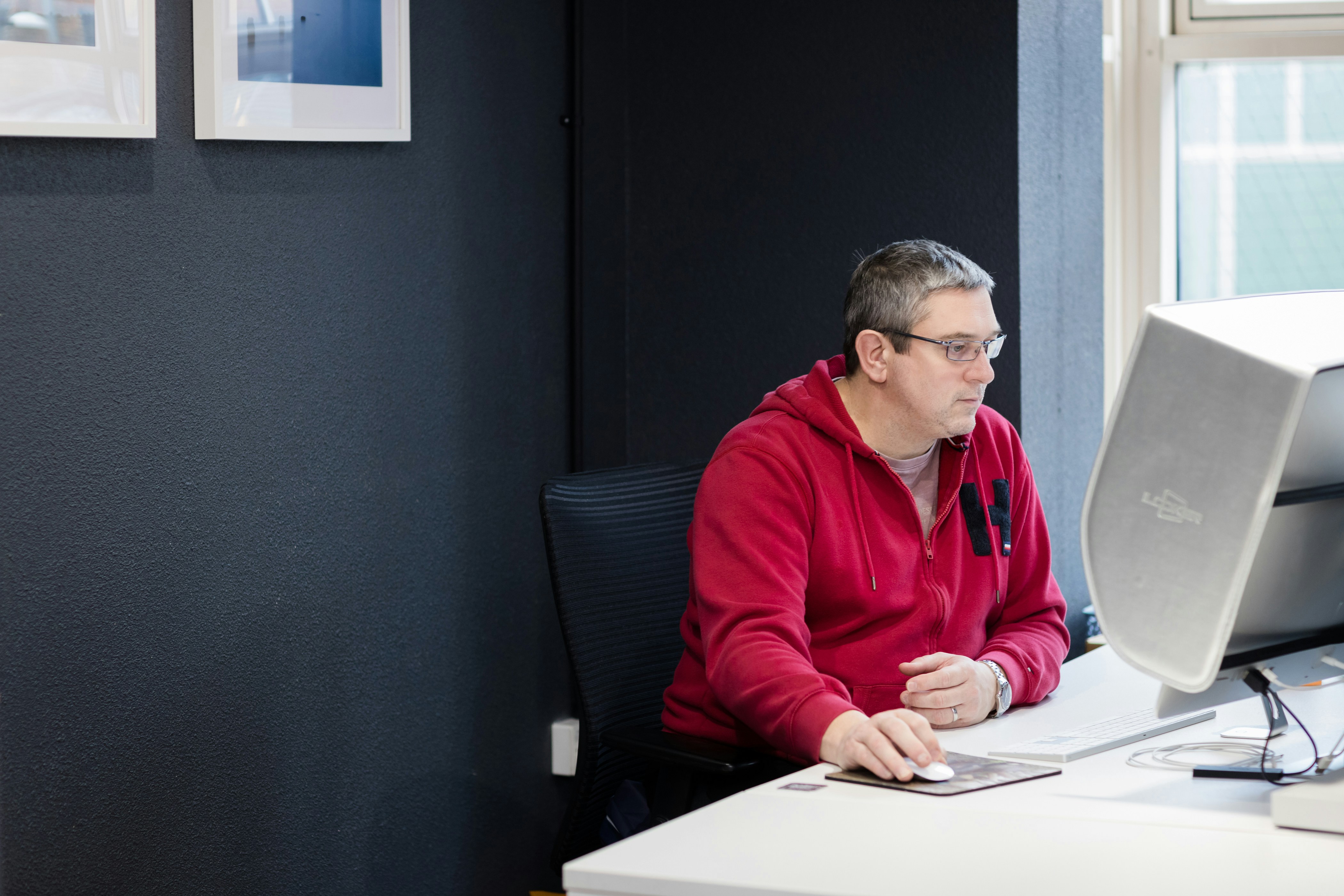 A man sitting at a desk in front of a computer photo – Free Office ...