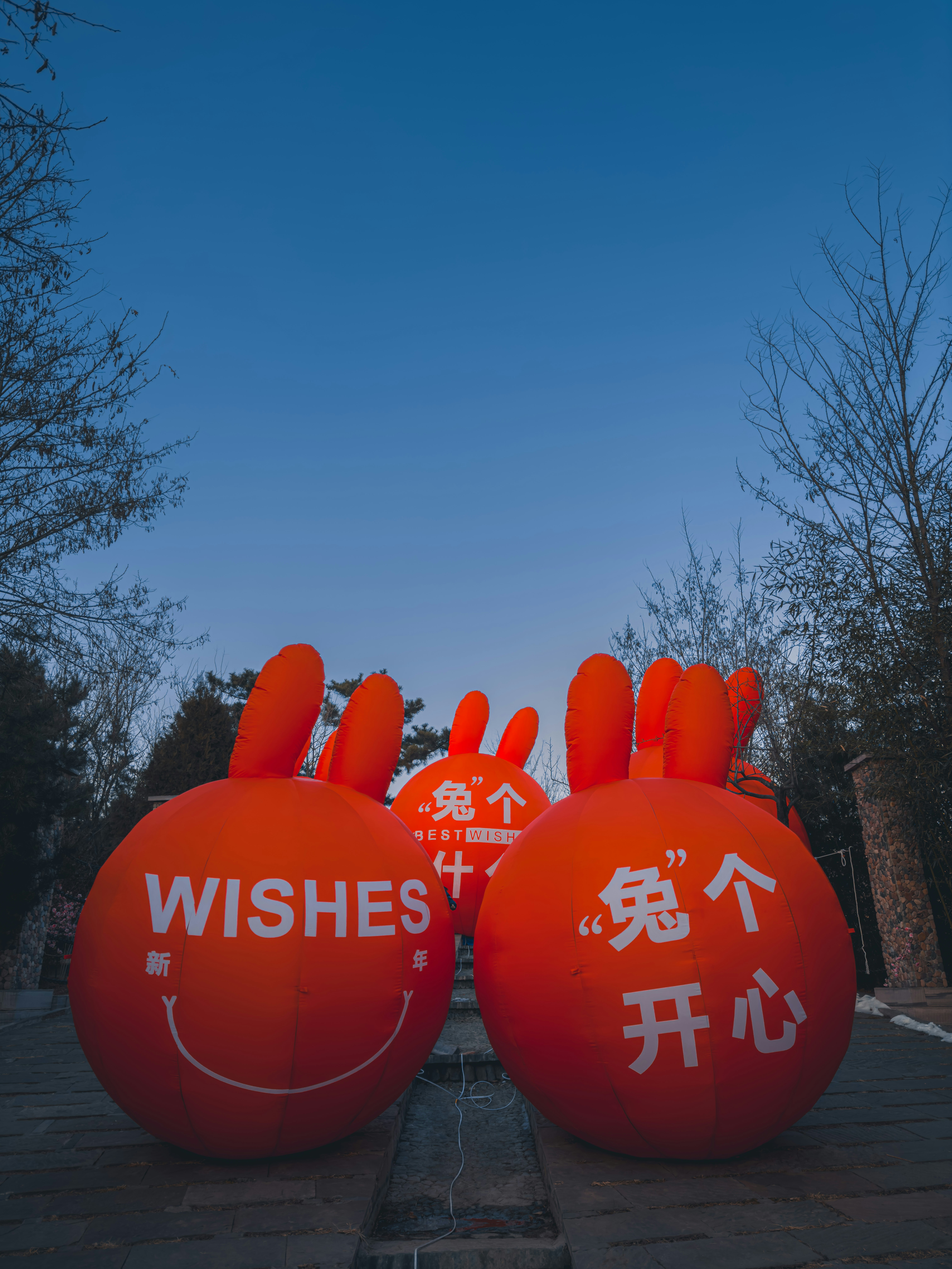 two large orange balloons sitting on top of a sidewalk
