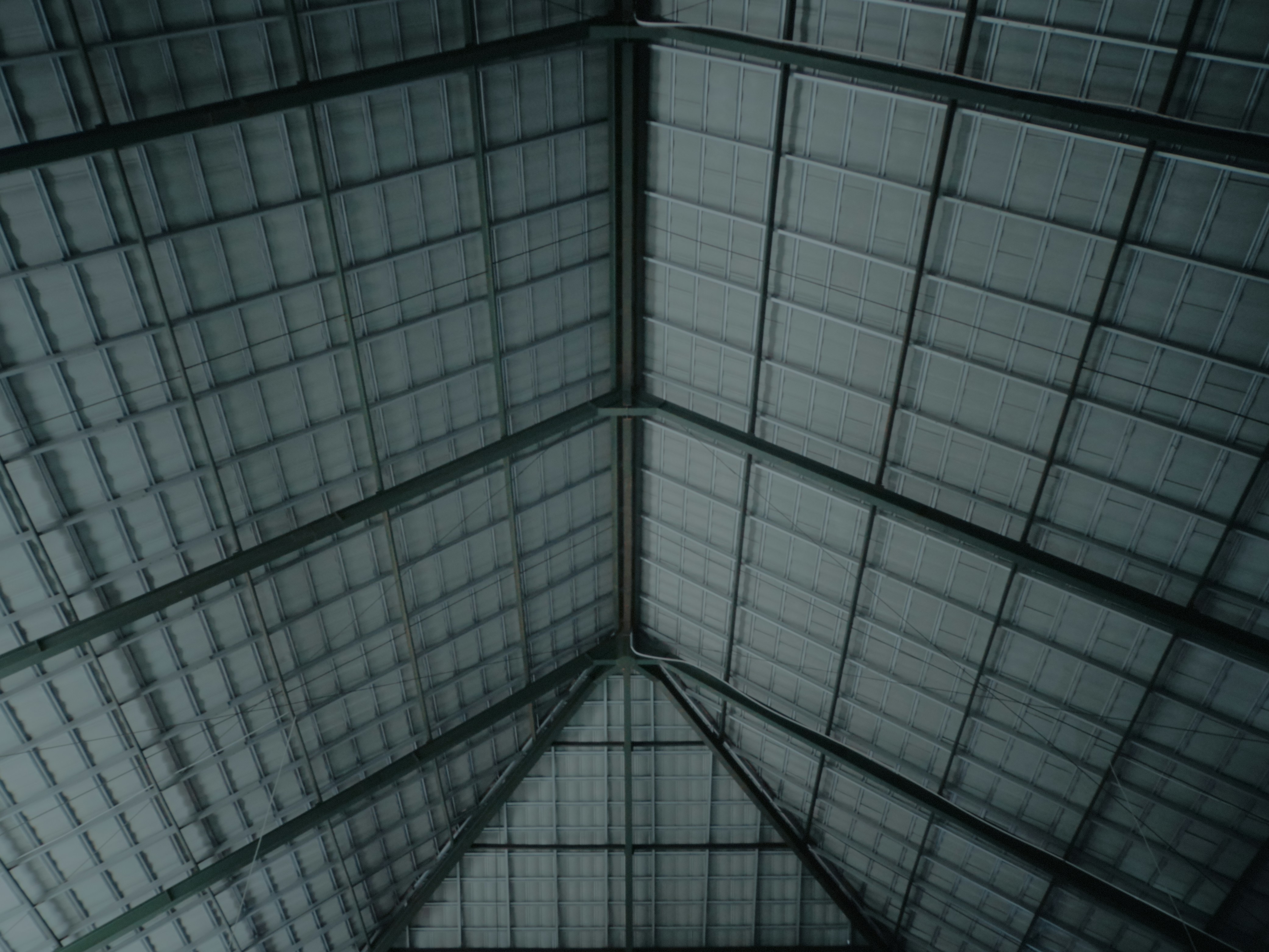 Steel roof | a view of the ceiling of a large building