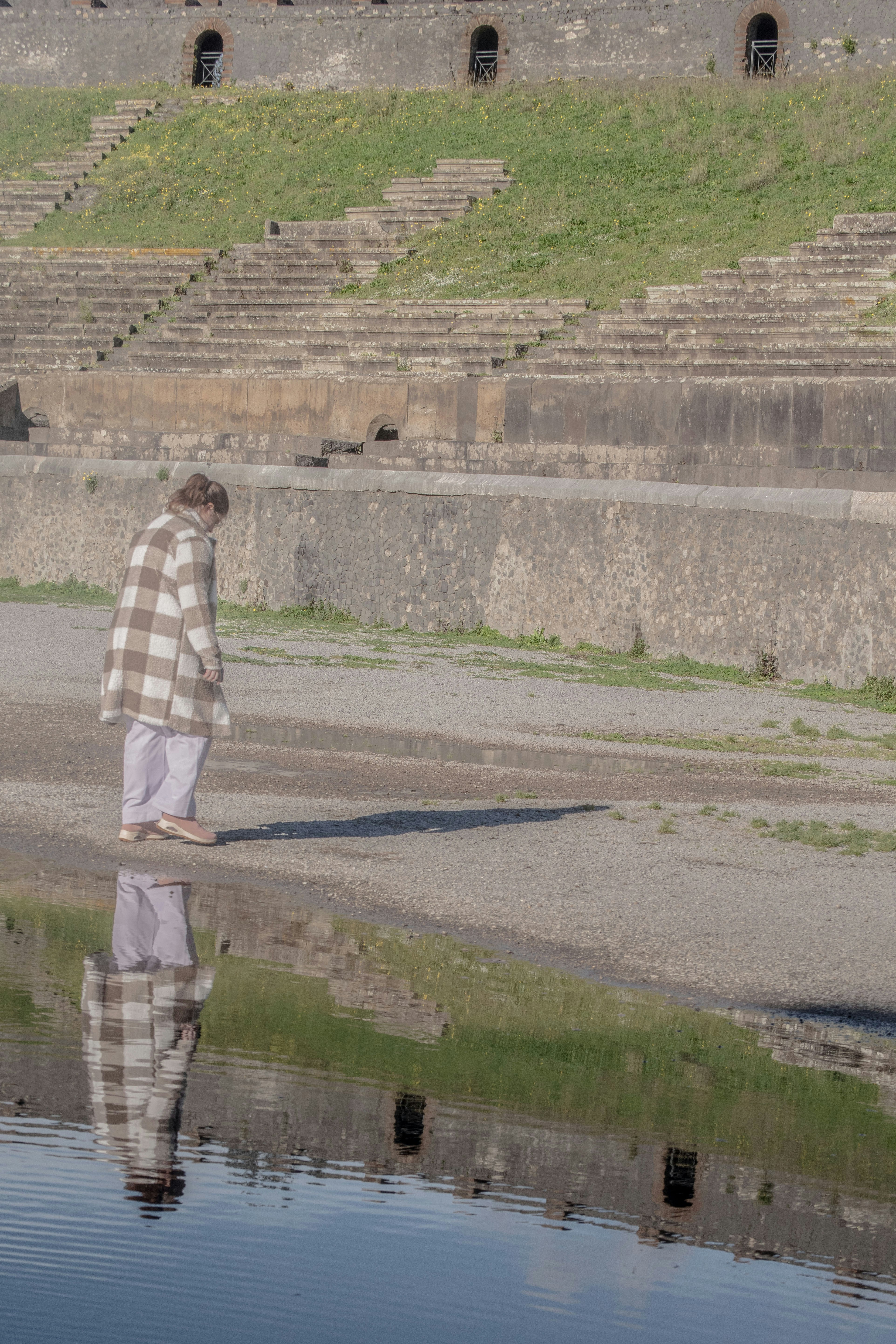 Lonely wanderer by the ancient ramparts and its mirrored pond