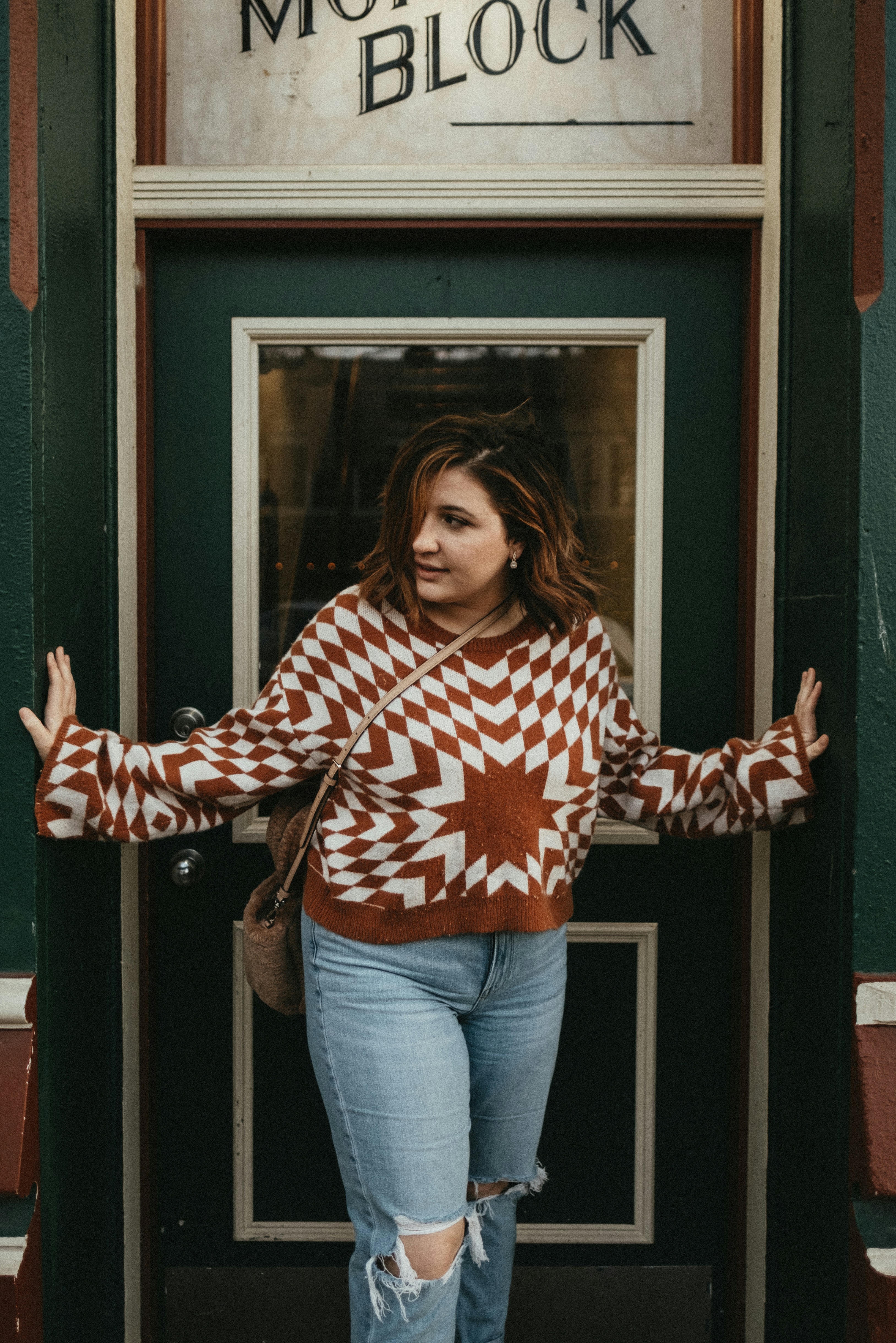 Geometric Warmth on a Doorstep: A Woman in a Patterned Knit at a Vintage Threshold