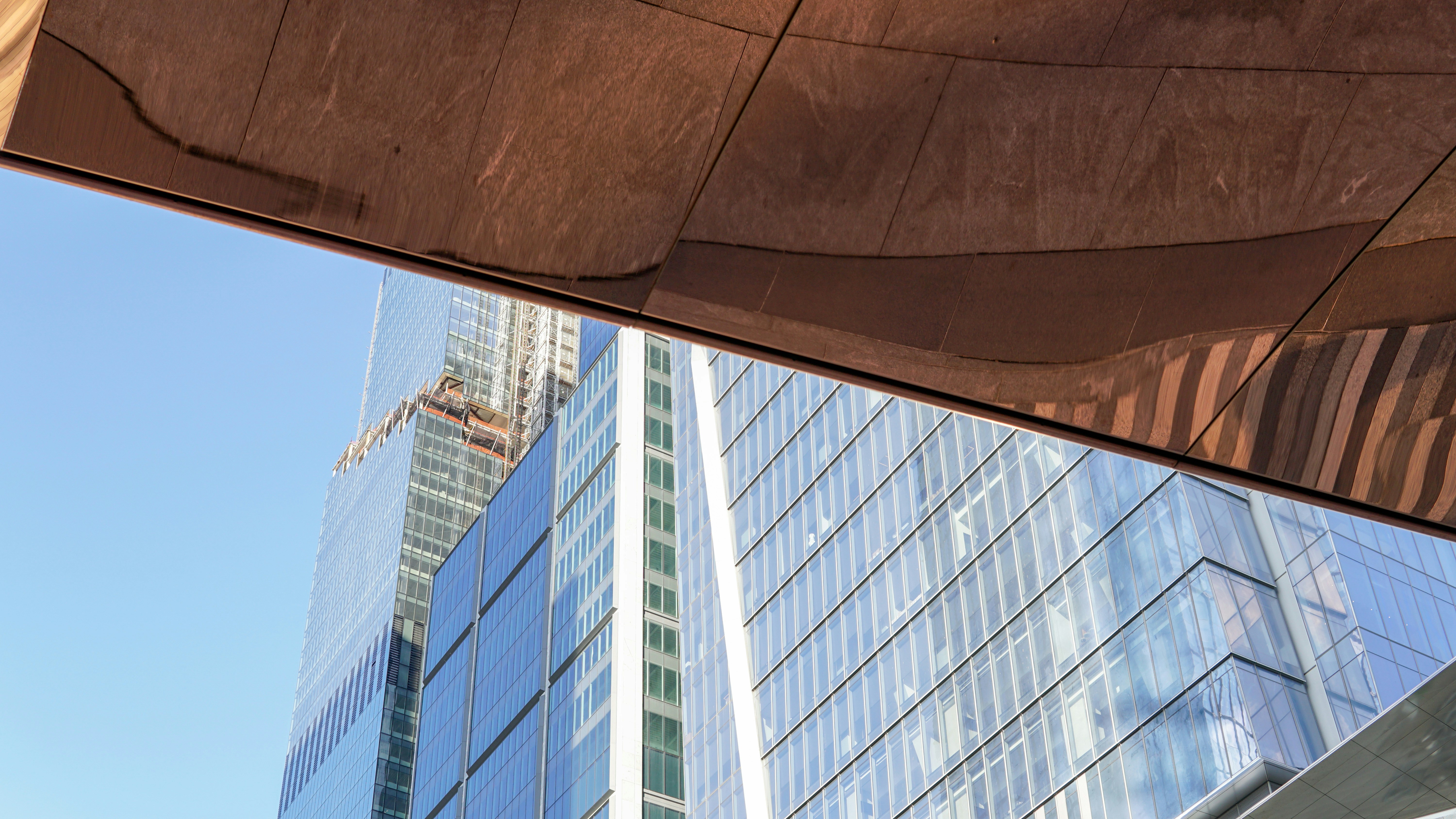 Azure Facades Framed by a Copper Canopy: Urban Geometry in Downtown Light
