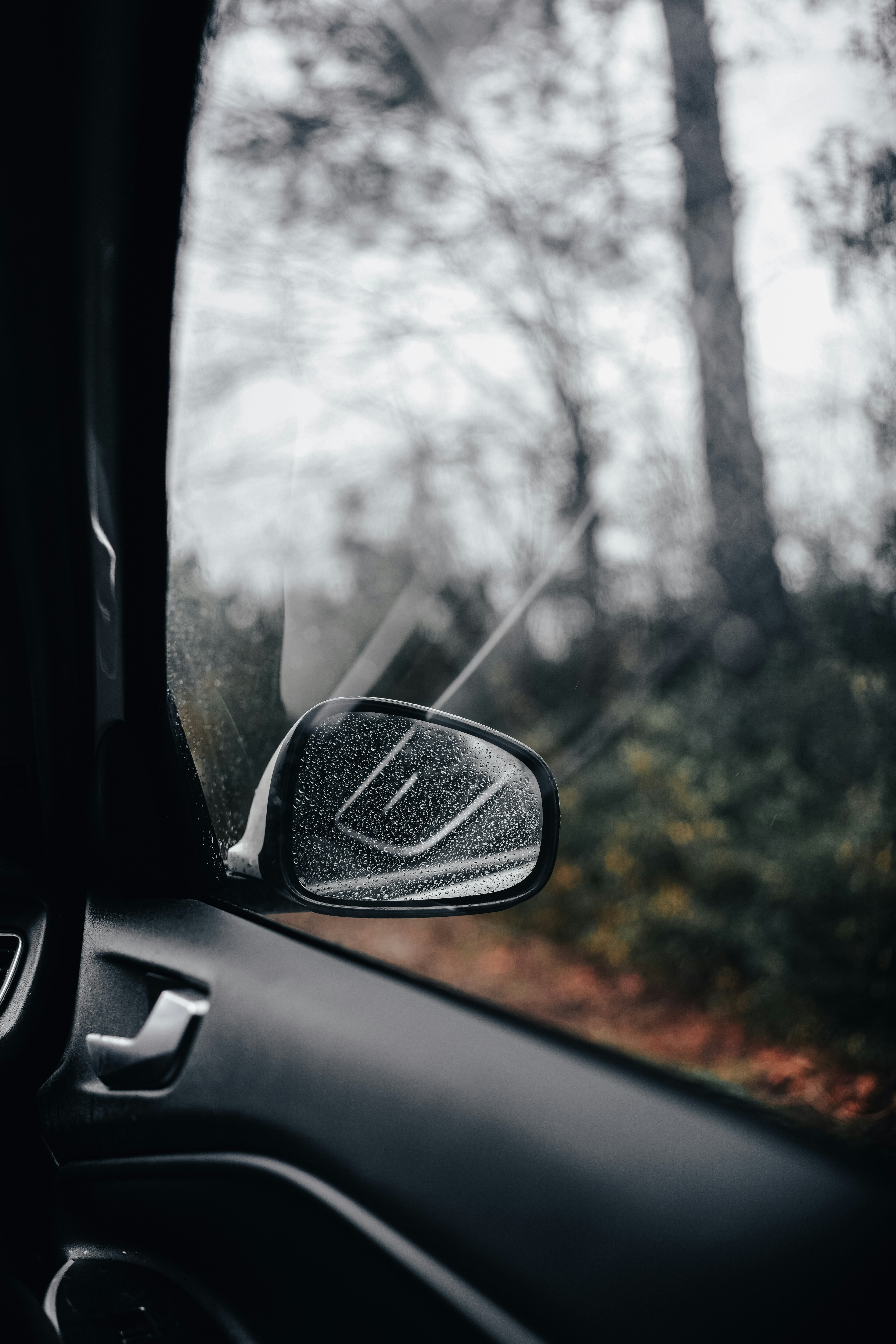 Rain-Kissed Side View: A Quiet Drive Reflected in the Car Mirror