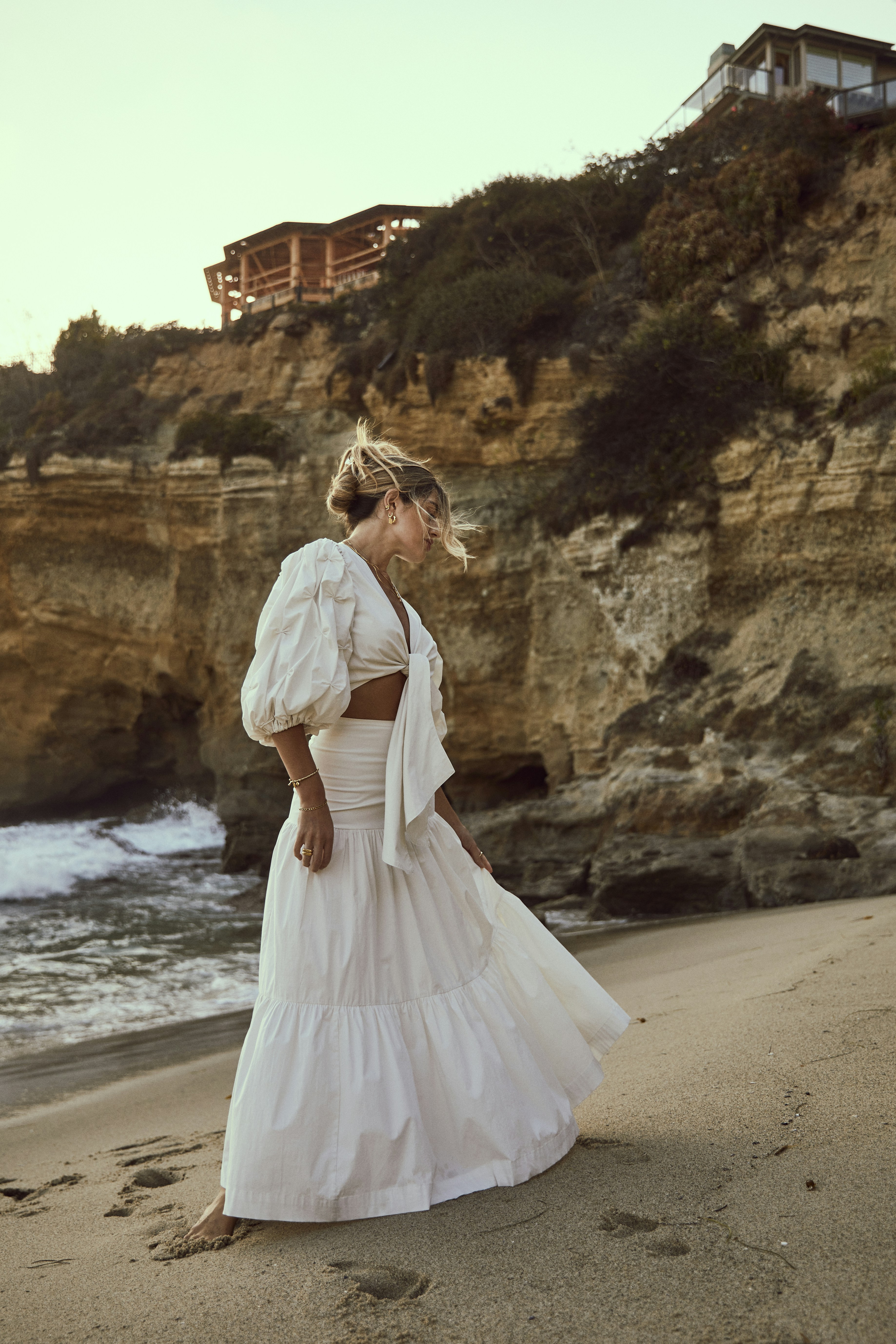a woman standing on top of a sandy beach