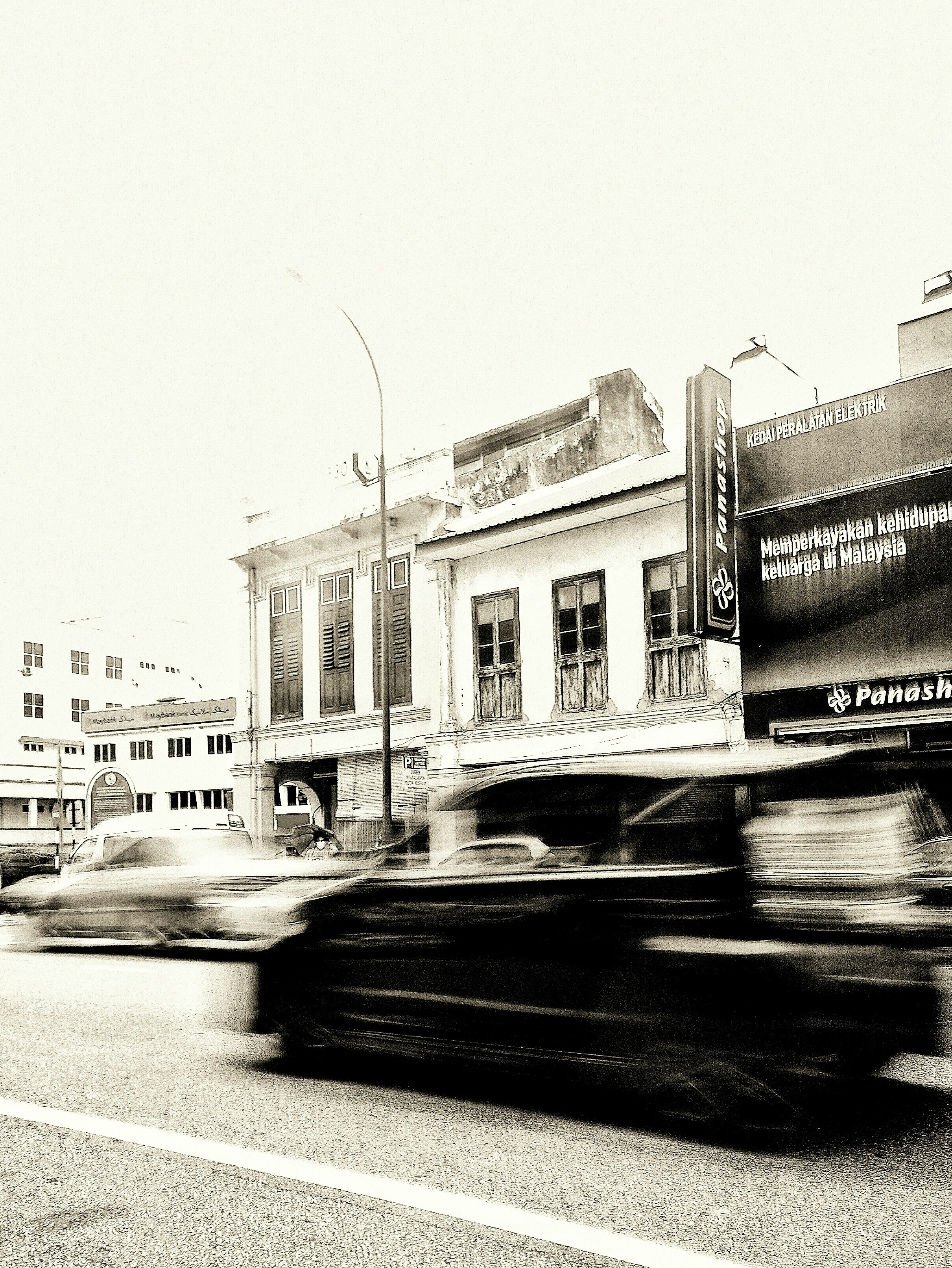 Blurred vehicles racing past historic buildings on a bustling street, showcasing the contrast between modern life and traditional architecture.