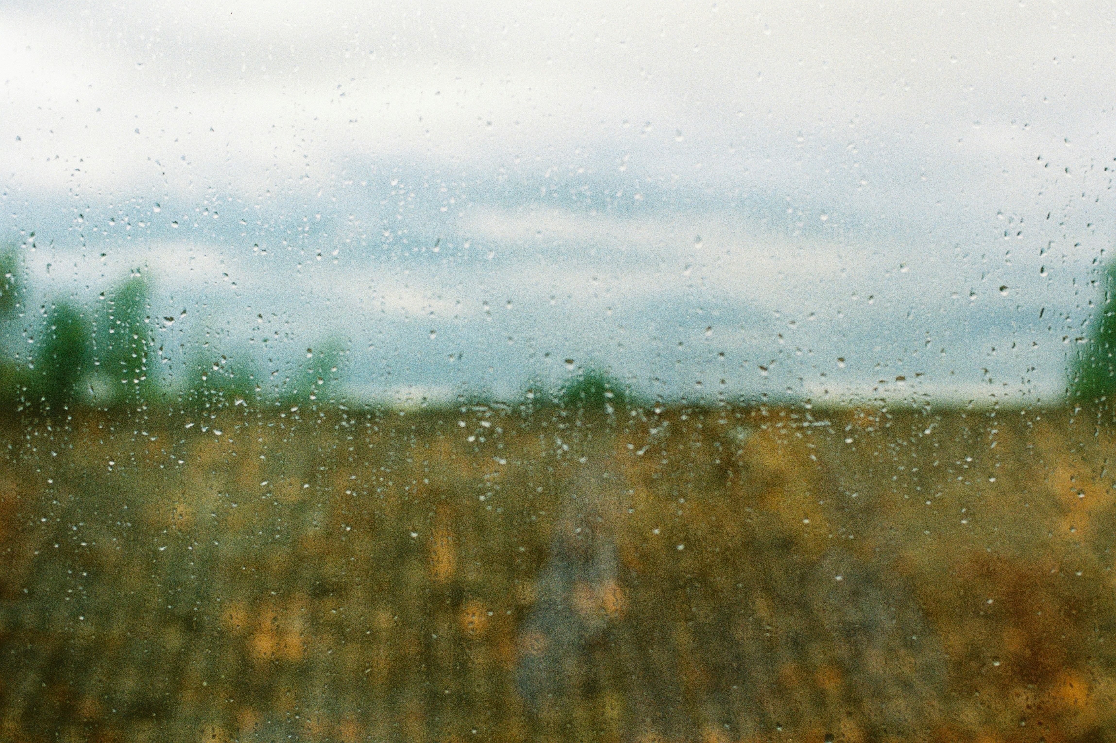 A view of a field through a rain covered window photo – Free Film ...