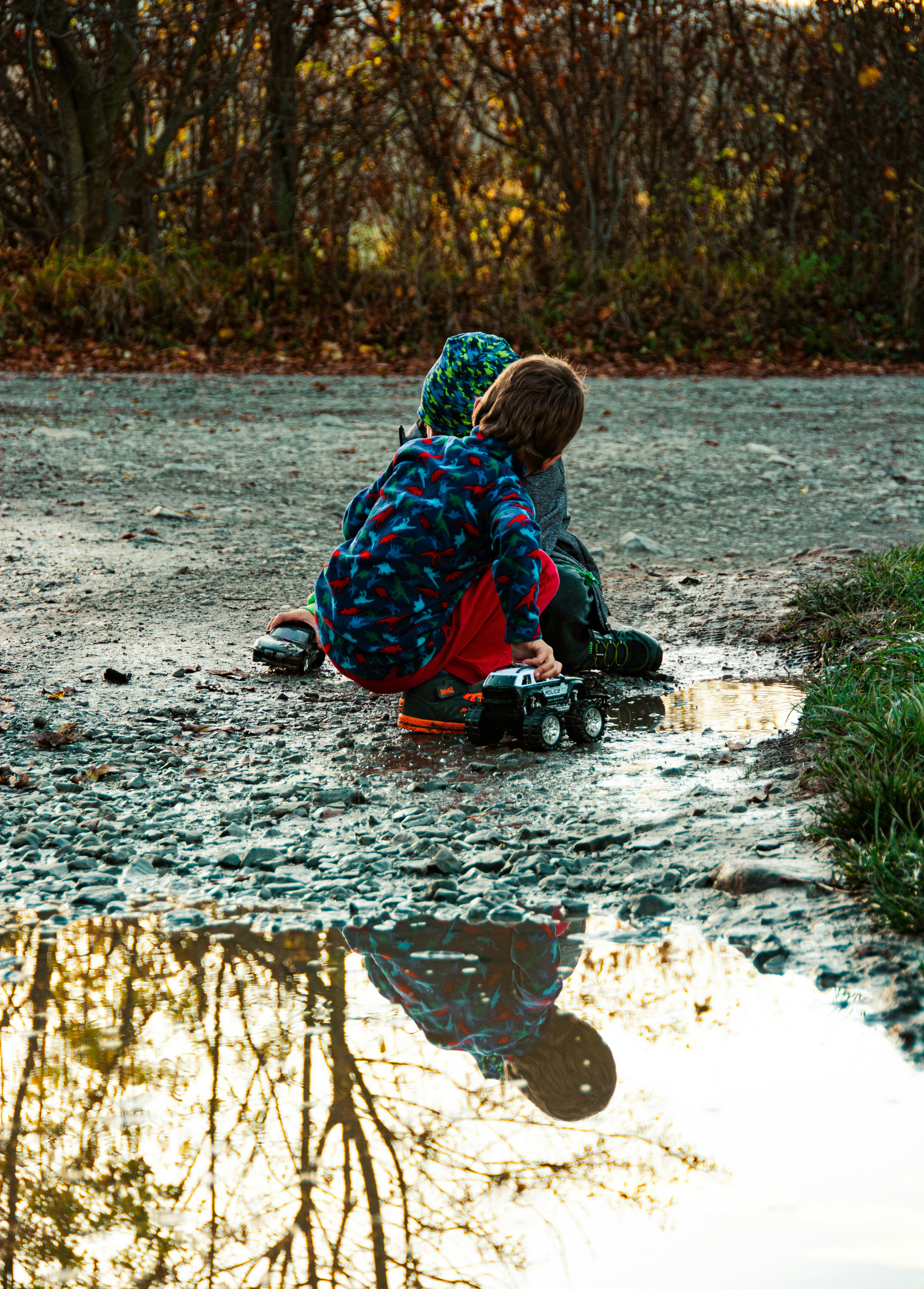 A person sitting on the ground next to a puddle photo – Free Rain Image ...