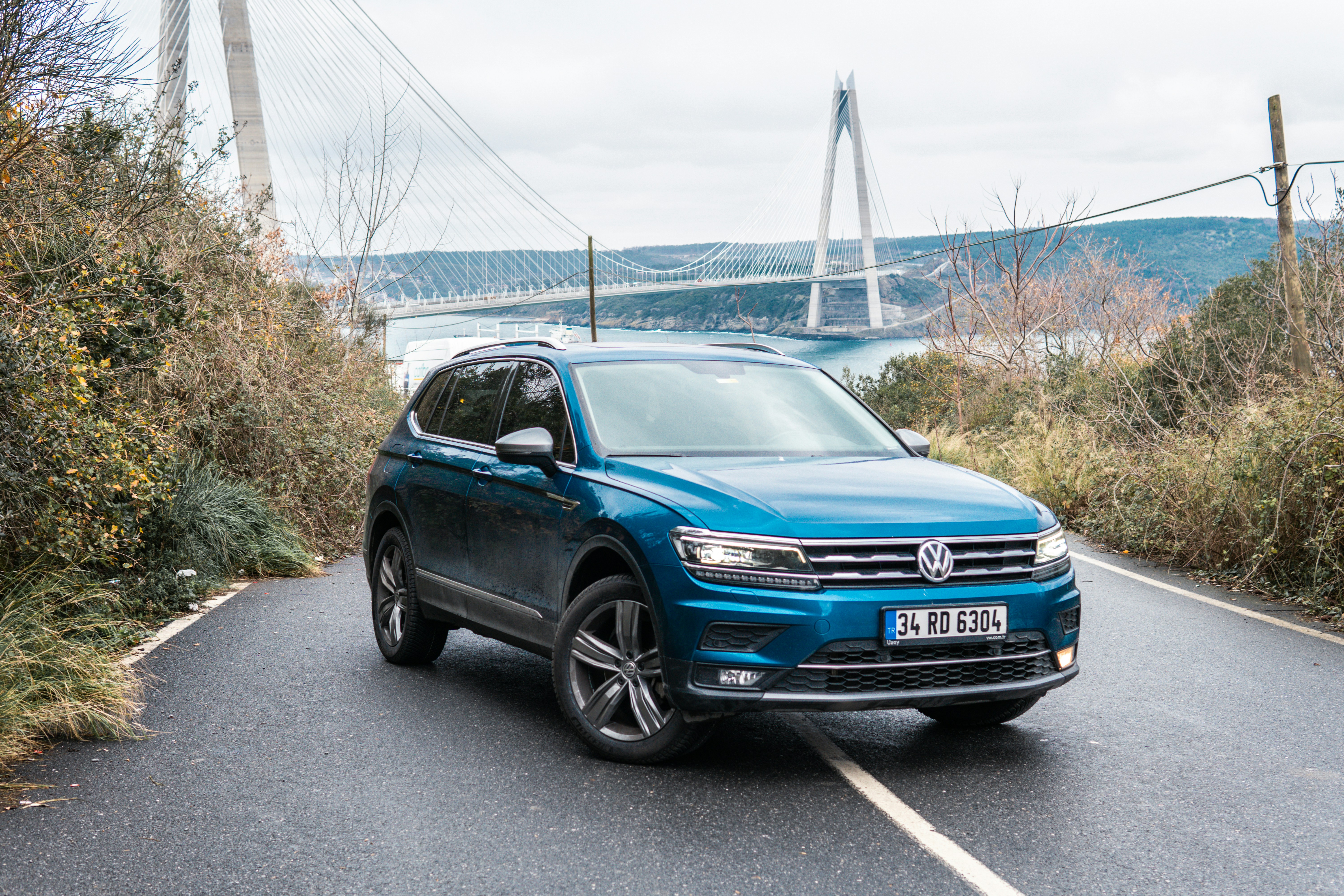Un VUS Volkswagen bleu roulant sur une route à côté d’un pont photo ...
