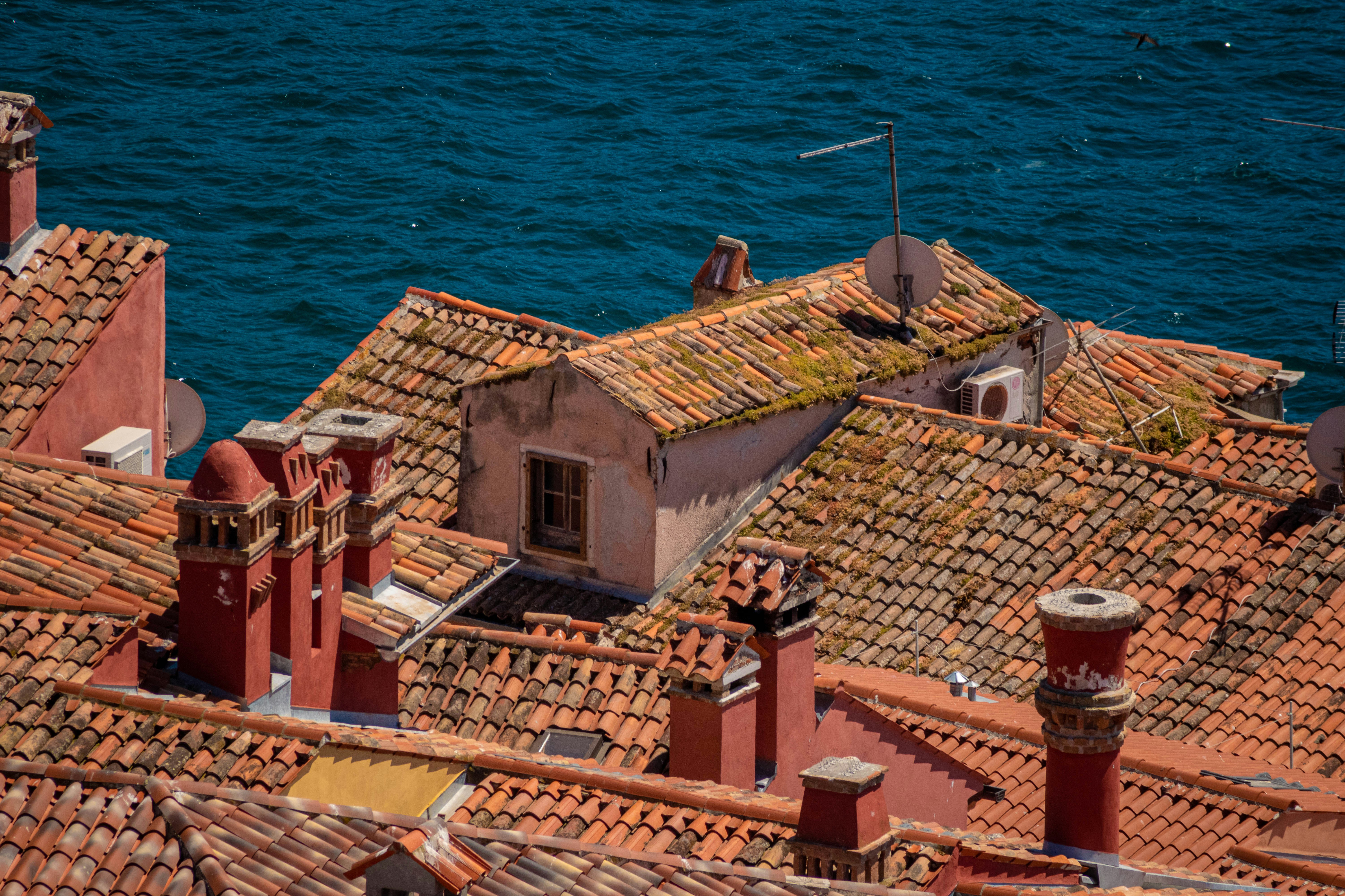 Terracotta Tapestry: Rooftops and Sea Light from an Aerial View