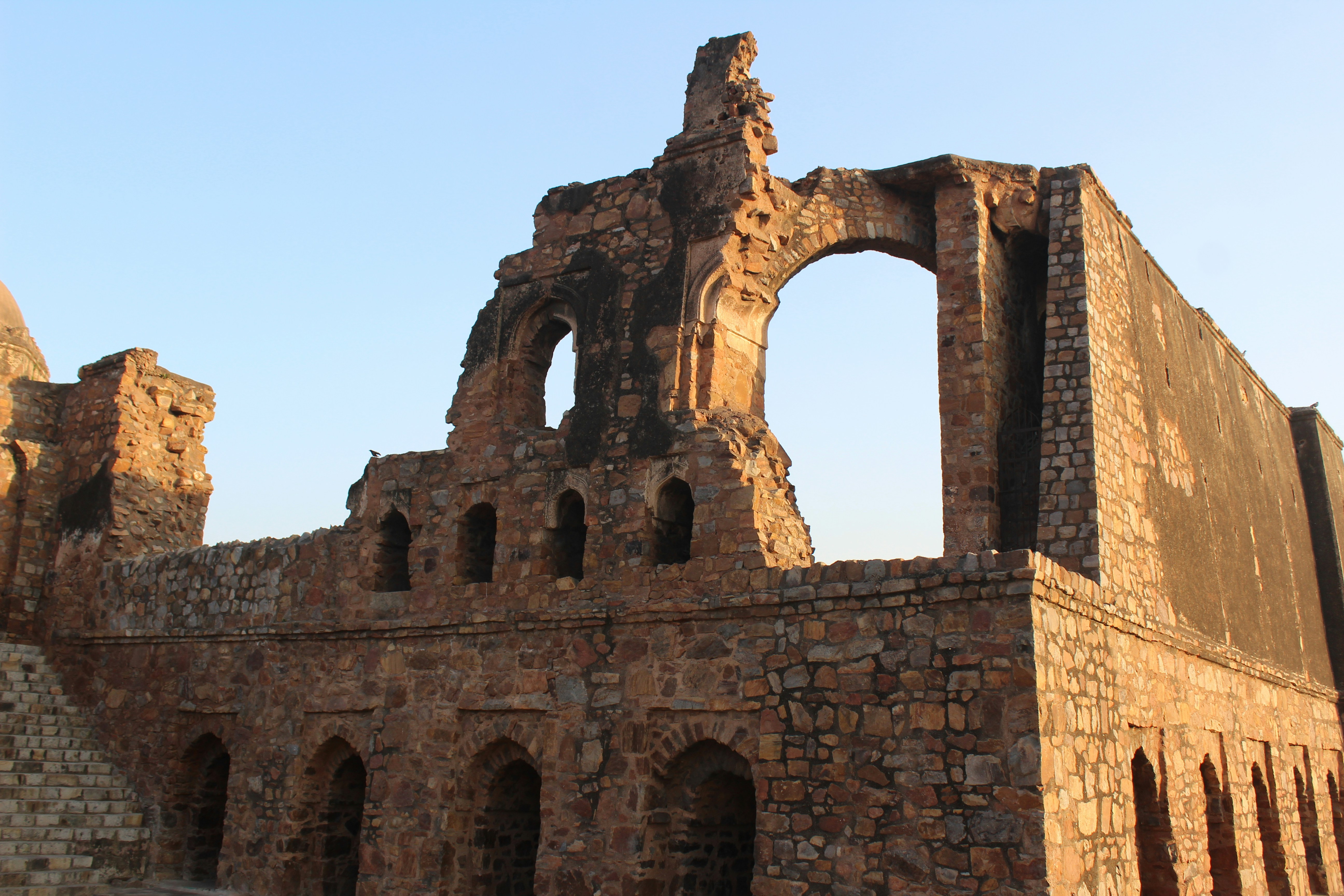 Feroz Shah Kotla | an old brick building with a clock tower in the background
