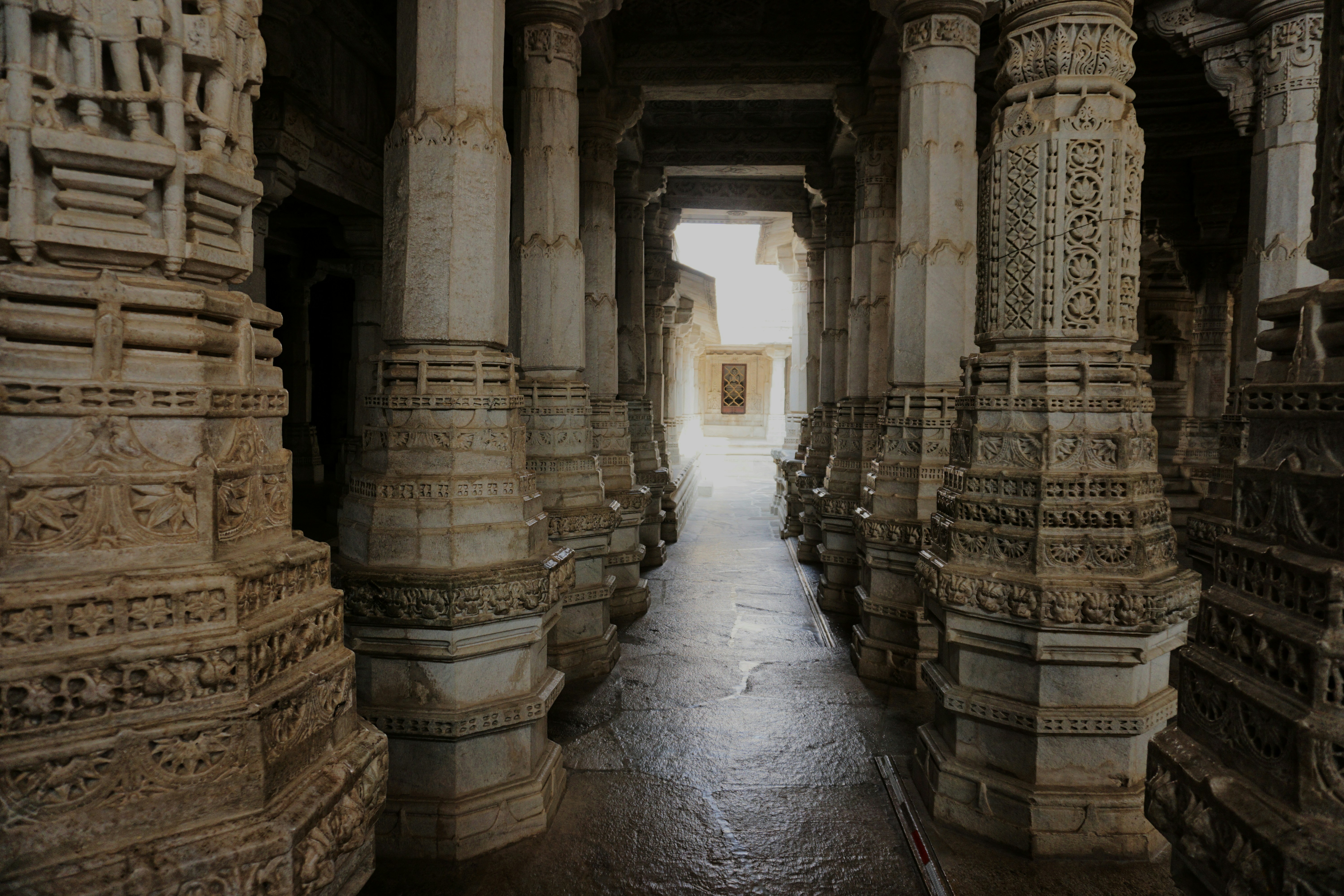 A narrow corridor between two buildings with carved pillars photo ...