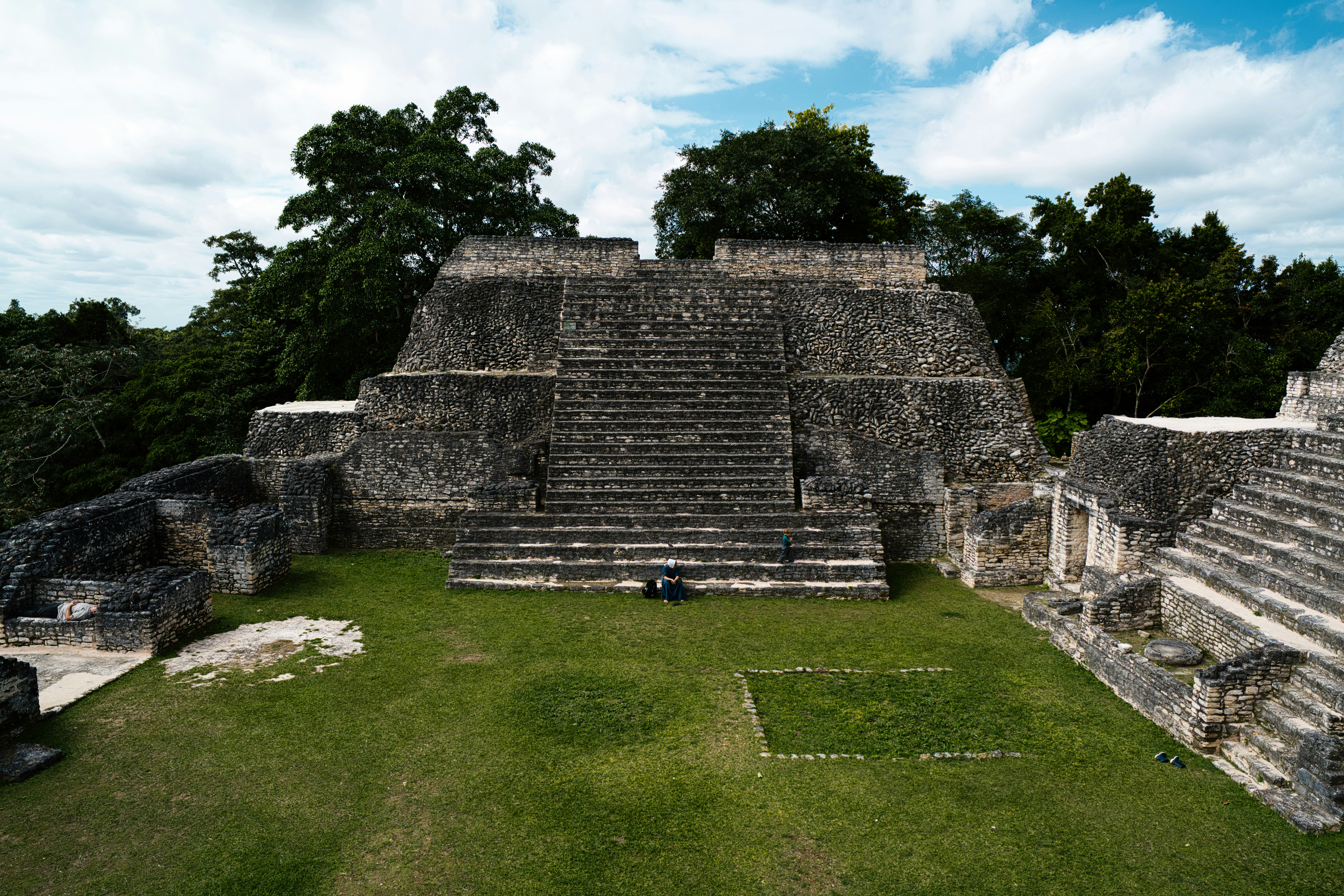 Stone steps of a Mayan temple rise amidst lush greenery, showcasing the remnants of a once-thriving culture.